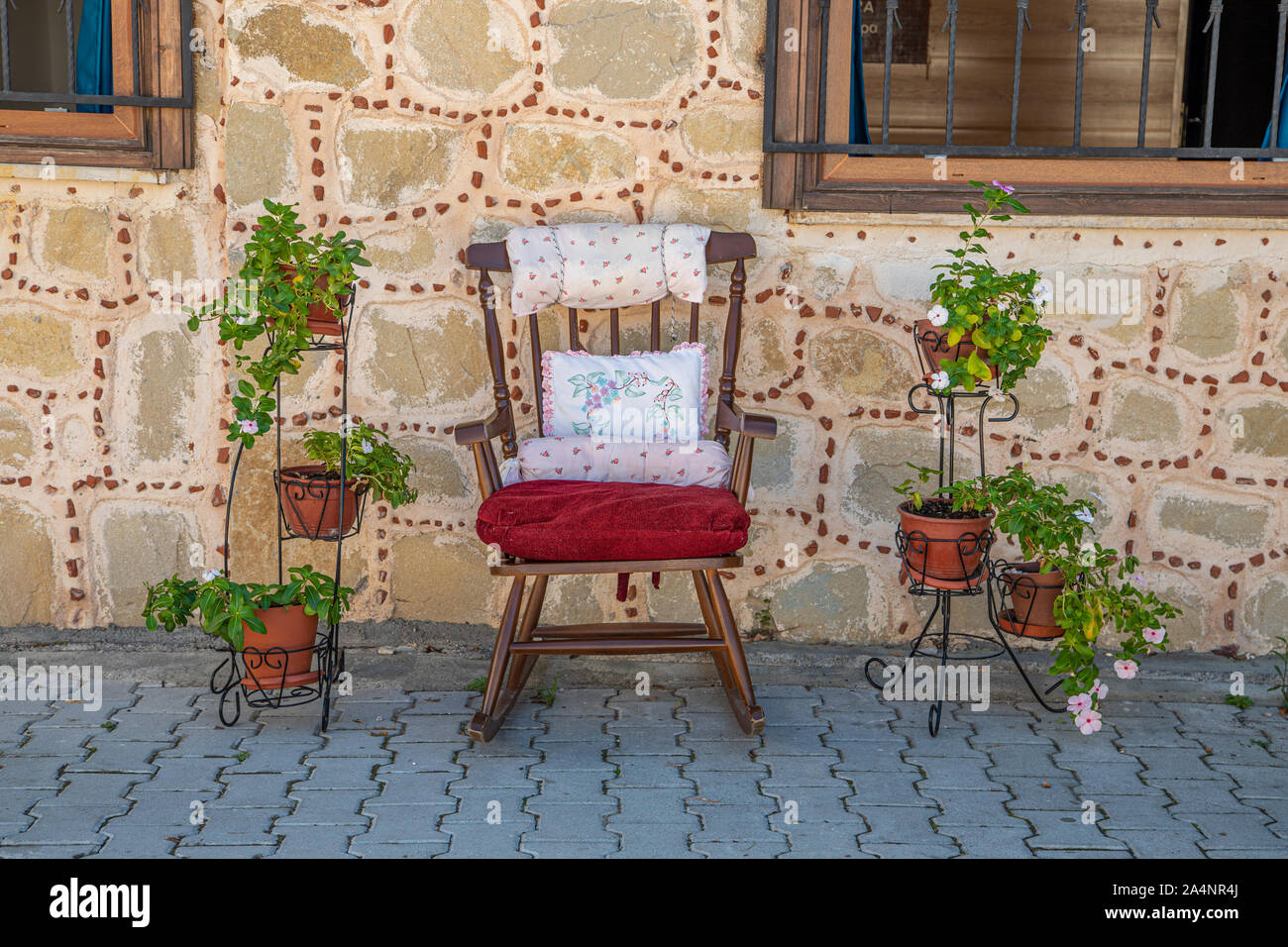 in an old street stands a decorative rocking chair and left and right ...