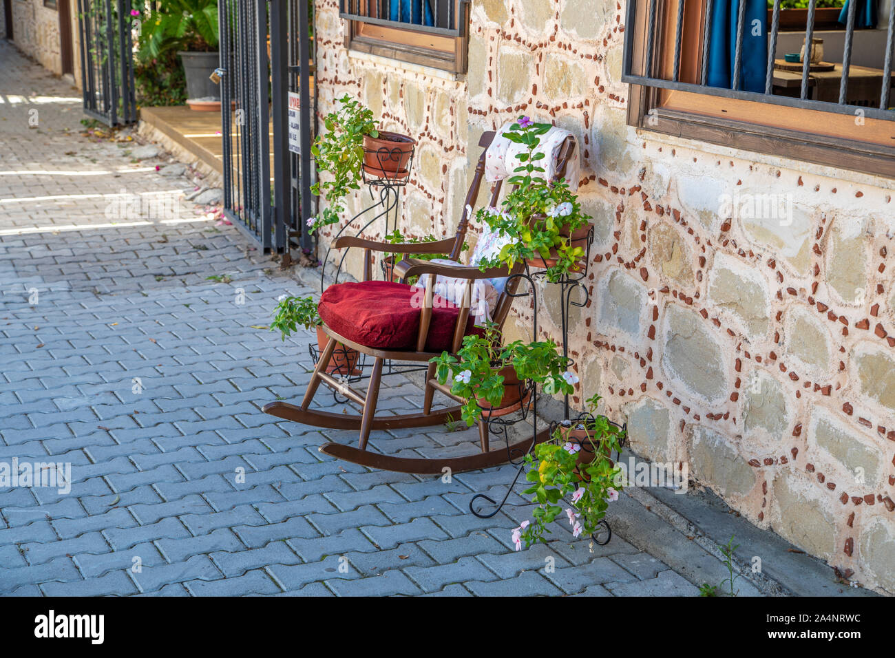 in an old street stands a decorative rocking chair and left and right ...