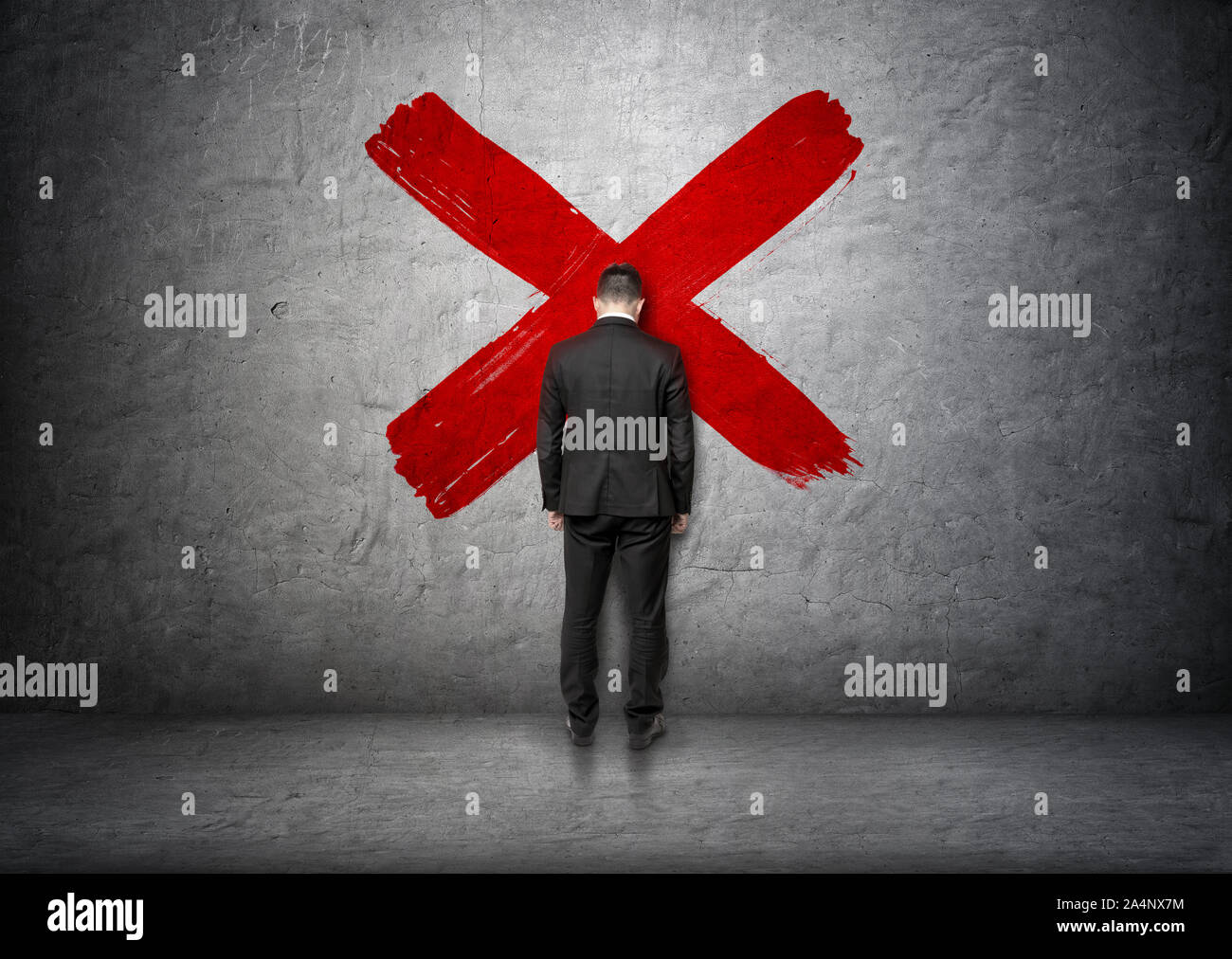 Businessman lean his forehead to concrete wall with big red cross in ...