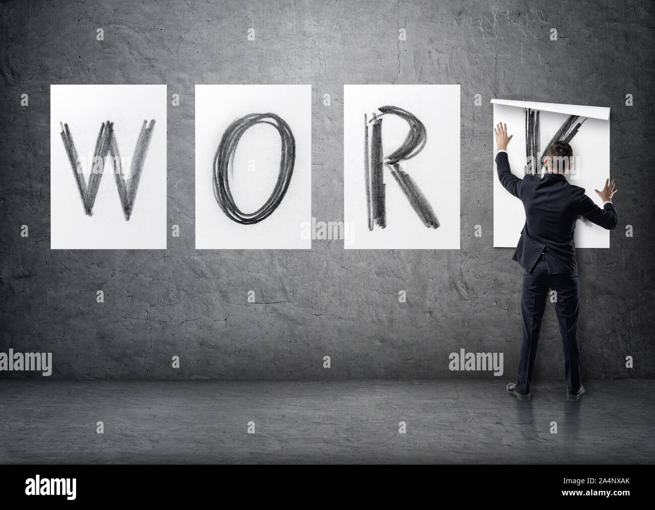 Businessman putting up posters with letters on concrete wall that form ...