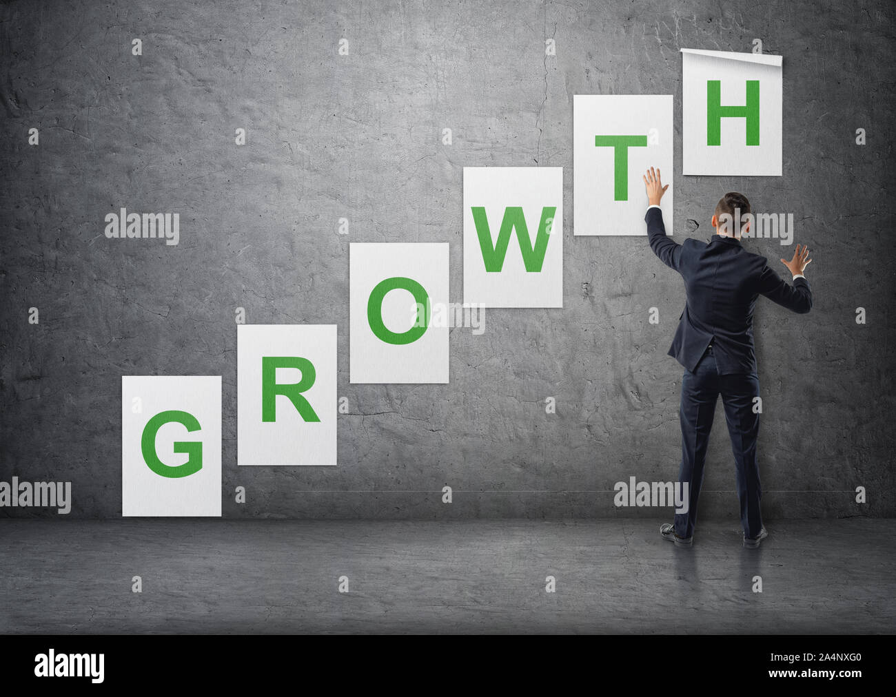 Businessman putting up posters with letters on concrete wall that form ...
