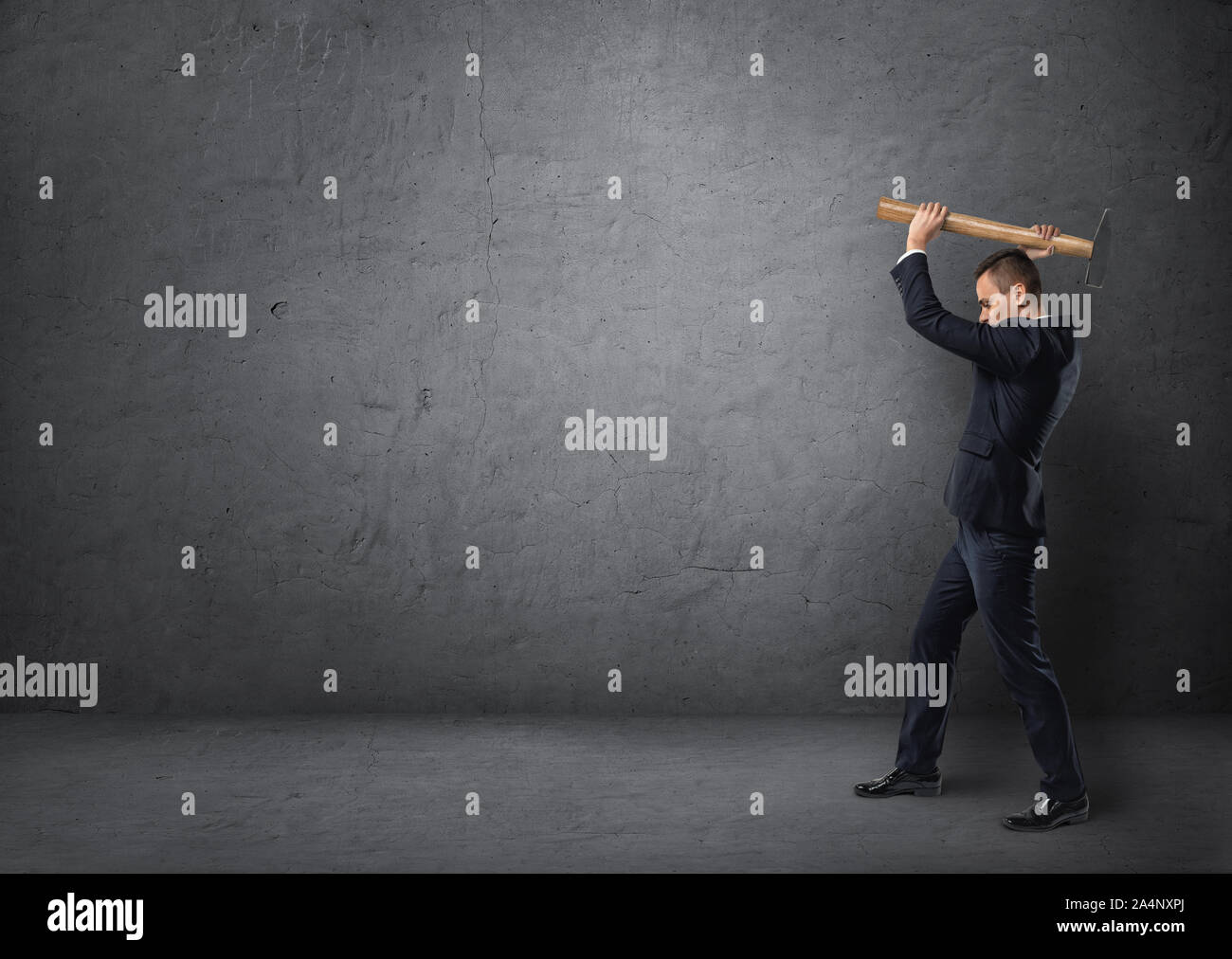 Side view of businessman with big hammer in his arms destroying ...