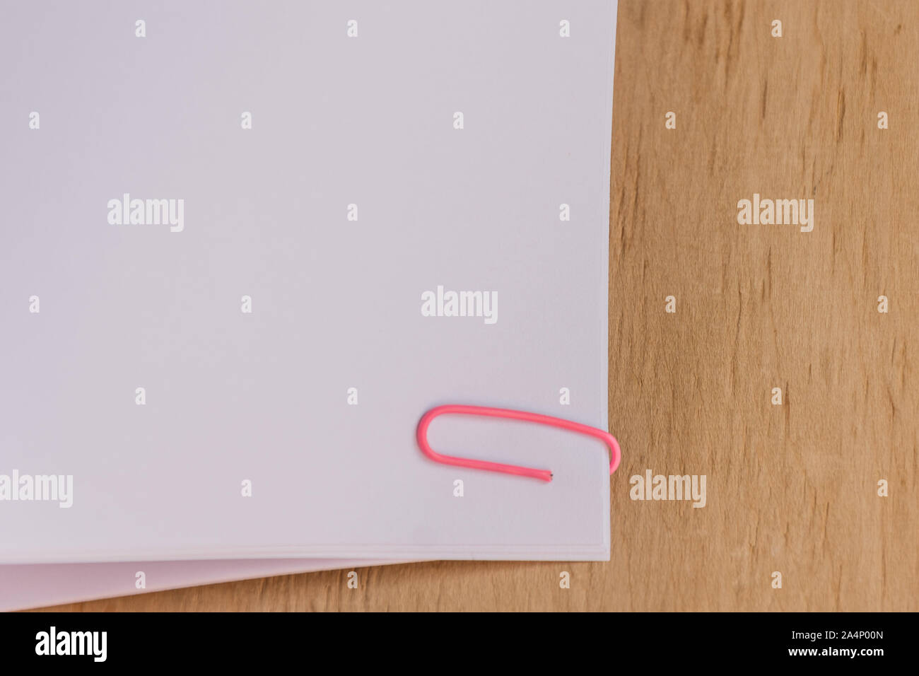 Blank paper clipped on wooden desk background. Office workplace. Mockup ...