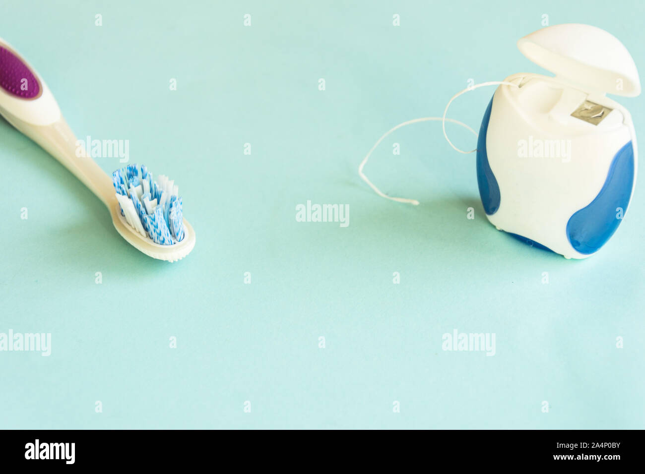 Toothbrush and dental floss on pastel colored background. Copy space ...