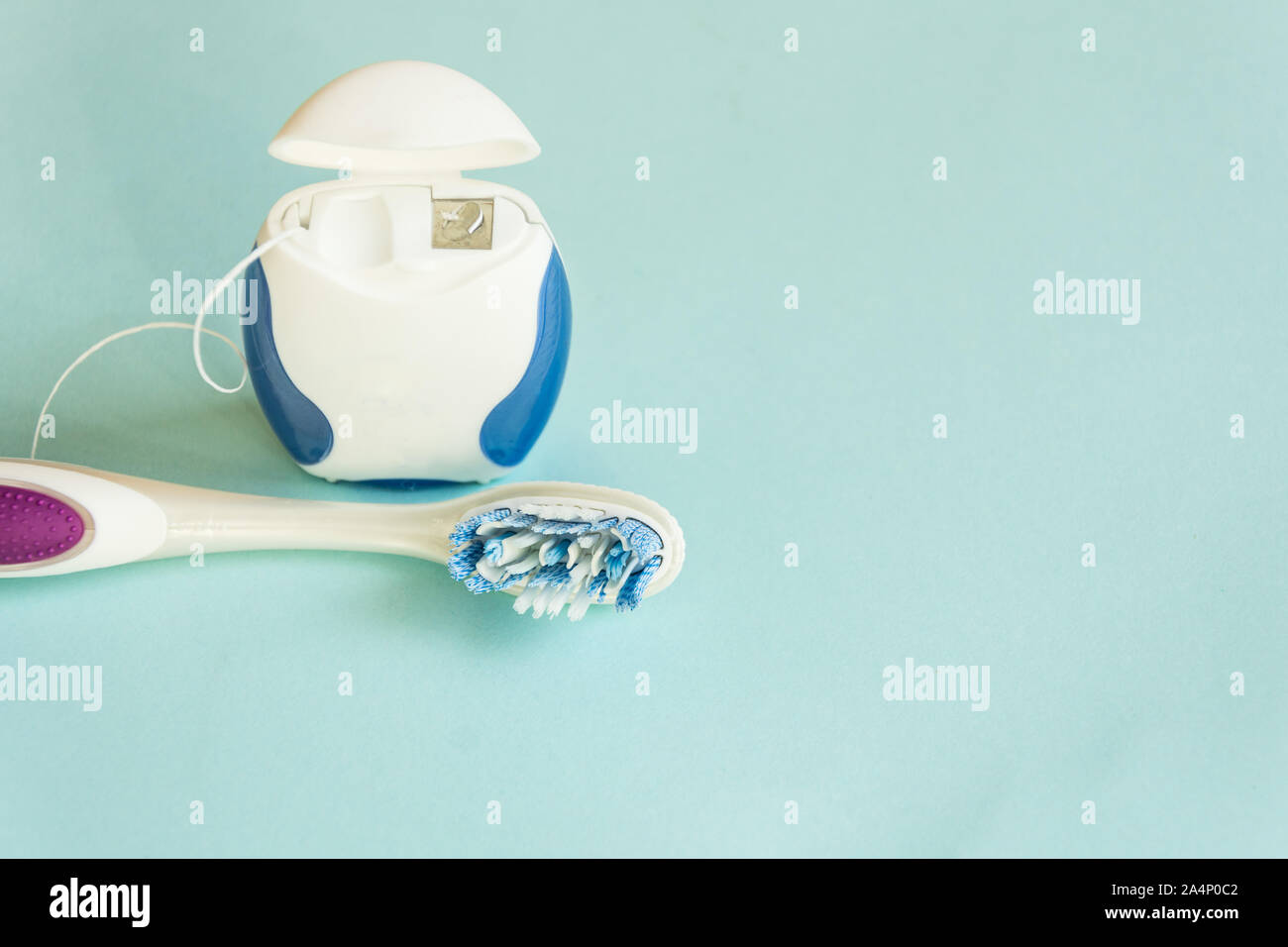 Toothbrush and dental floss on pastel colored background. Copy space ...