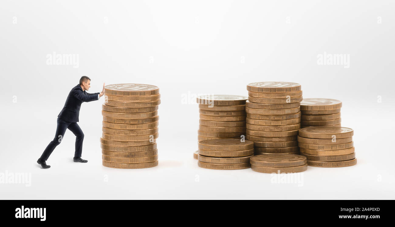 Small businessman pushing a stack of golden coins to another stacks ...