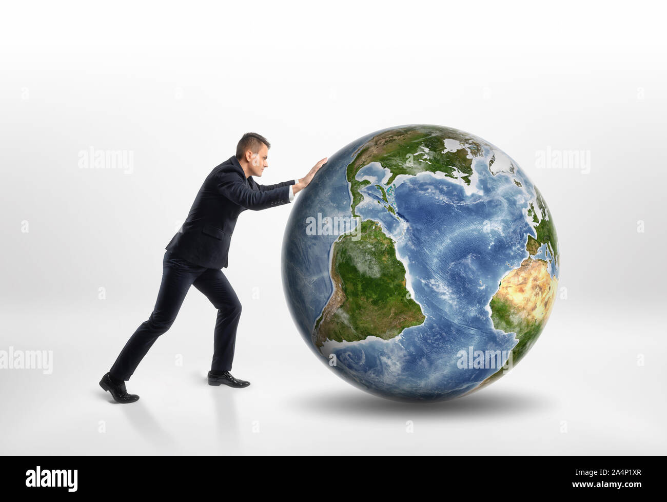 Side view of young businessman rolling the Earth isolated on white ...