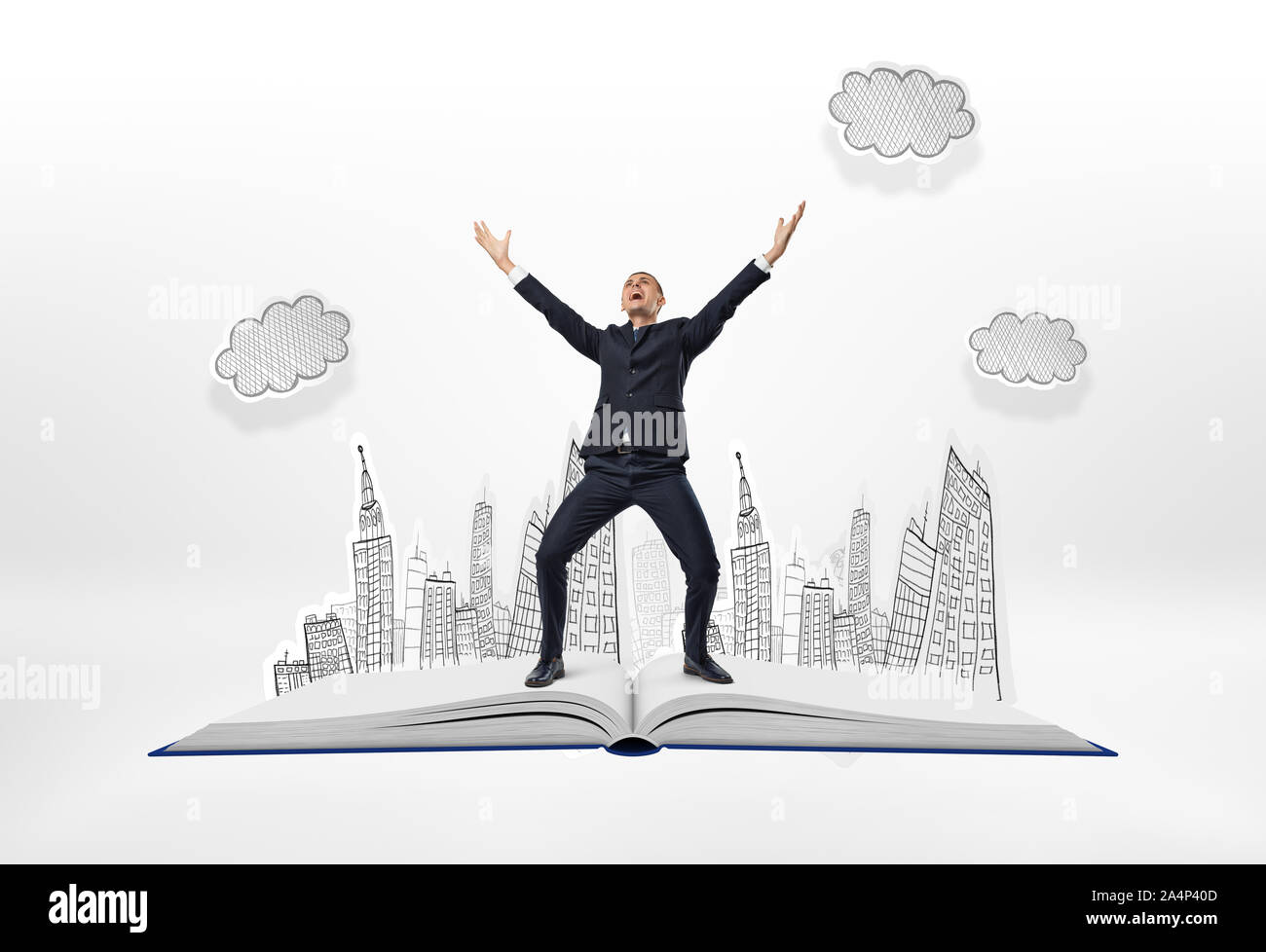 Happy businessman standing with his arms up on big opened book Stock ...