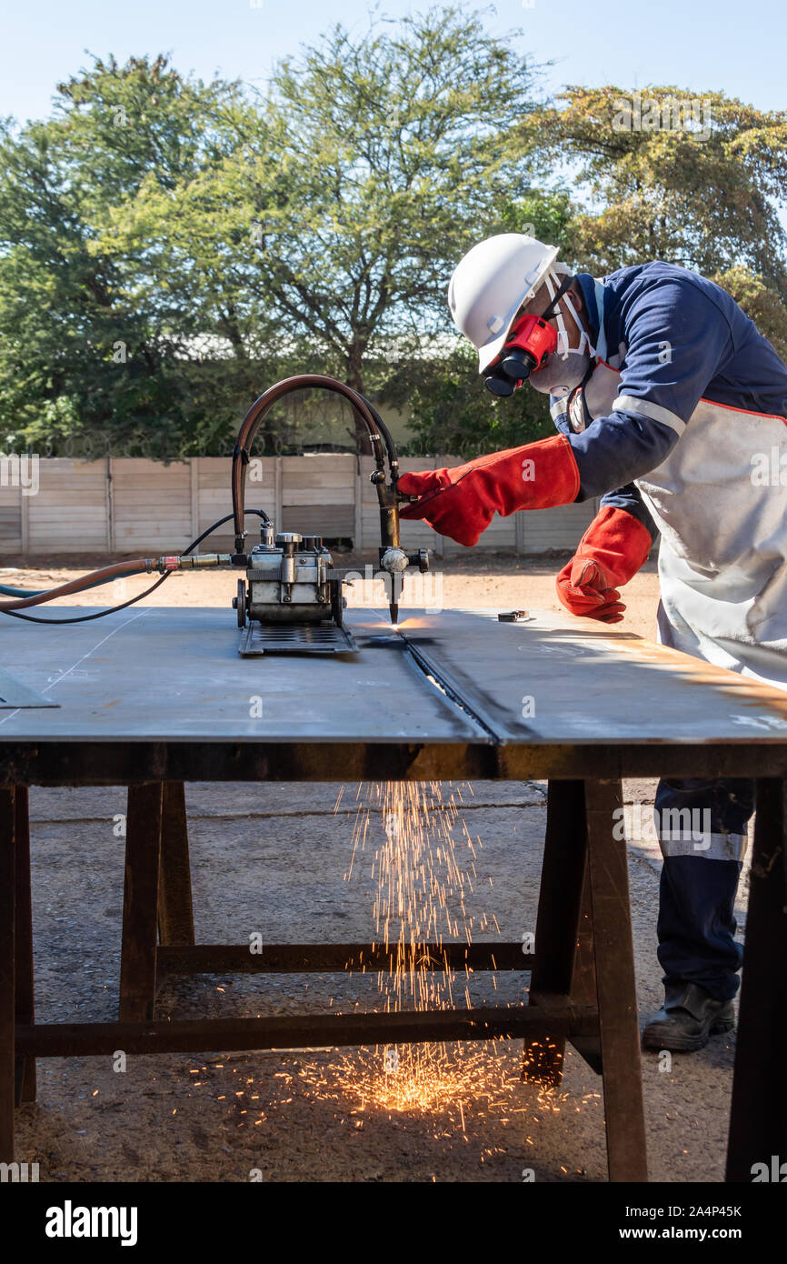 Motswana welder worker in a Botswana workshop, using an acetylene torch ...