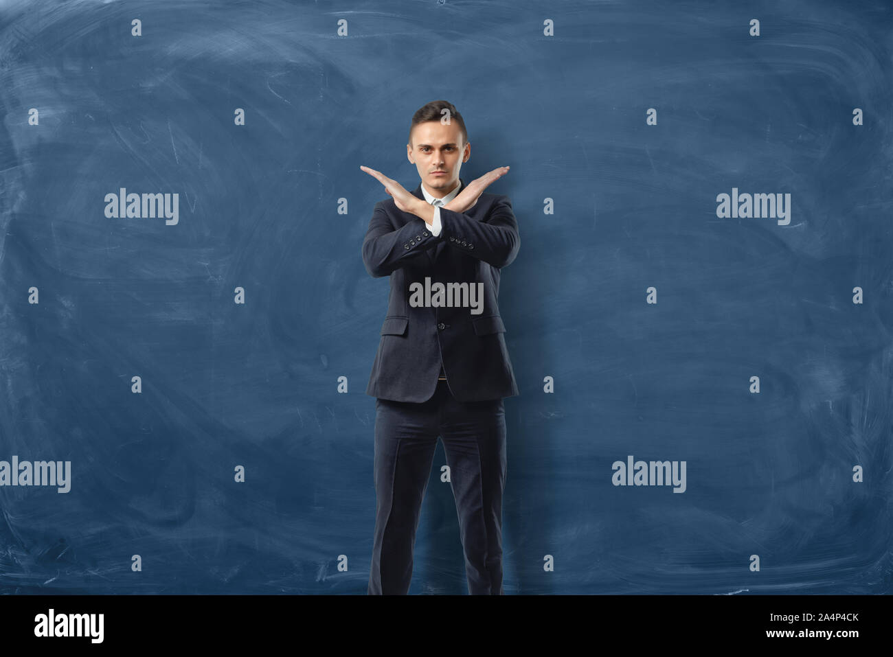 Serious businessman is making a stop sign with his hands isolated on ...