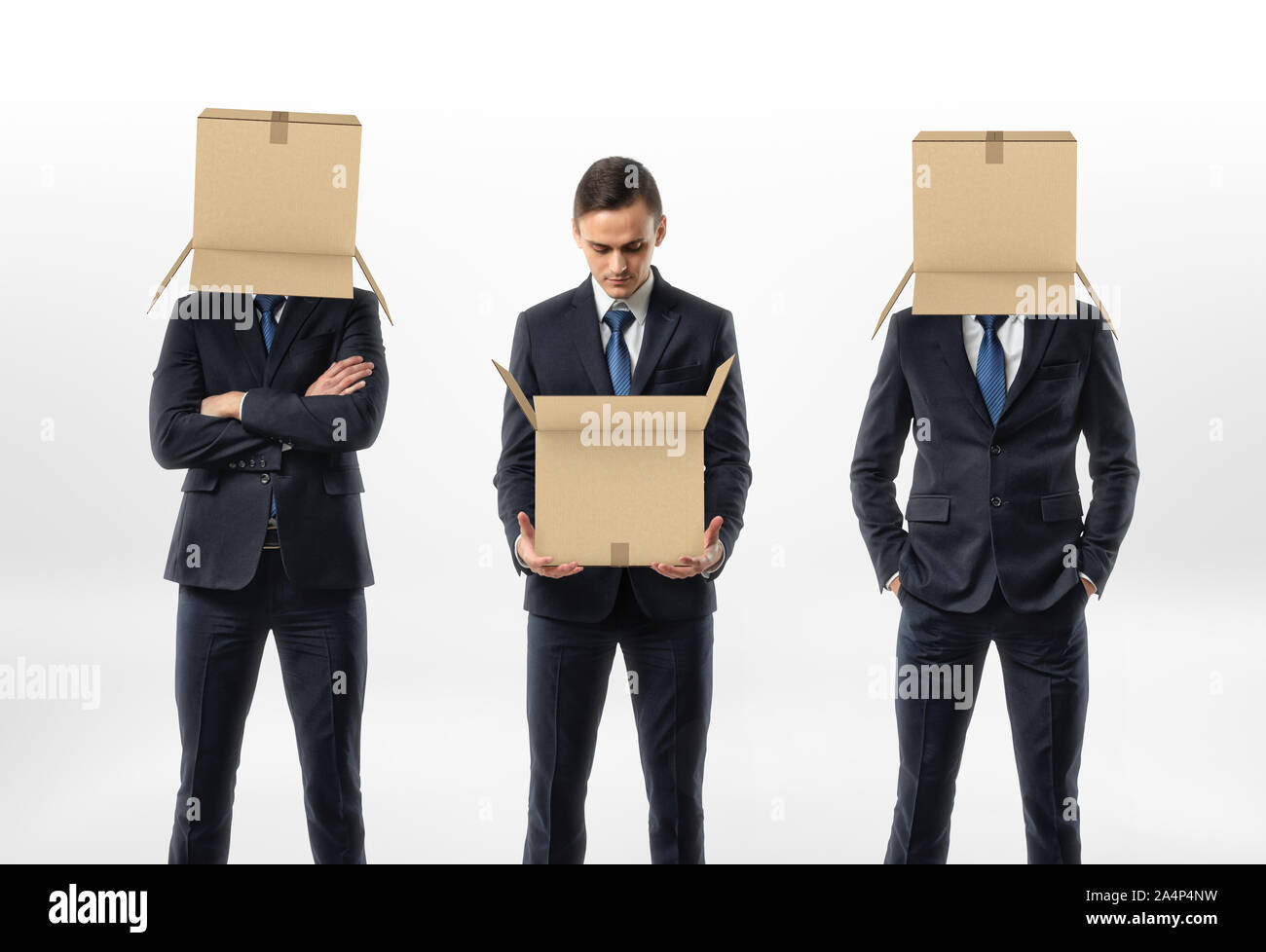 Businessman holding an open cardboard box, the other two are wearing ...