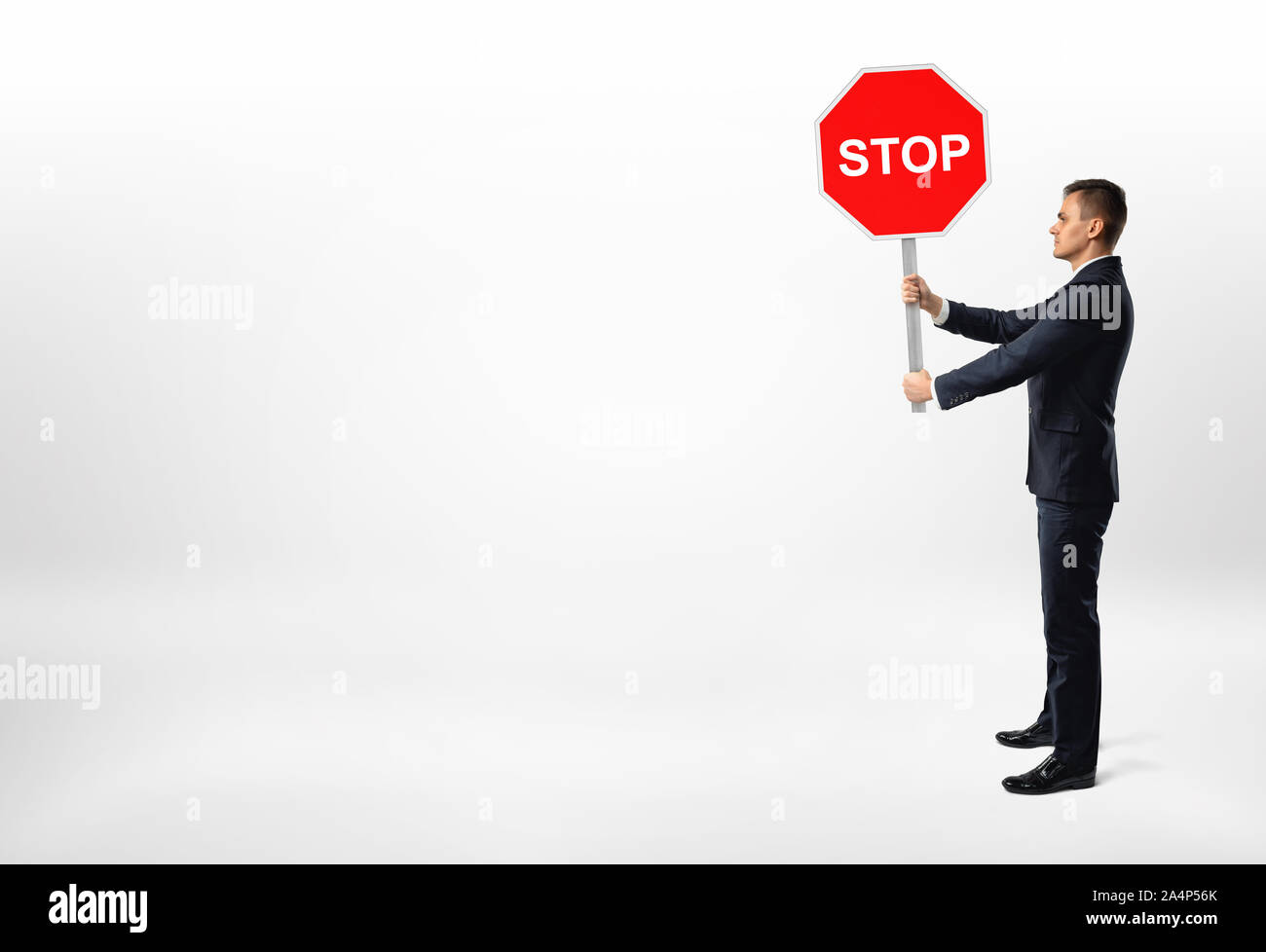 Businessman standing on white background and holding a stop sign Stock ...