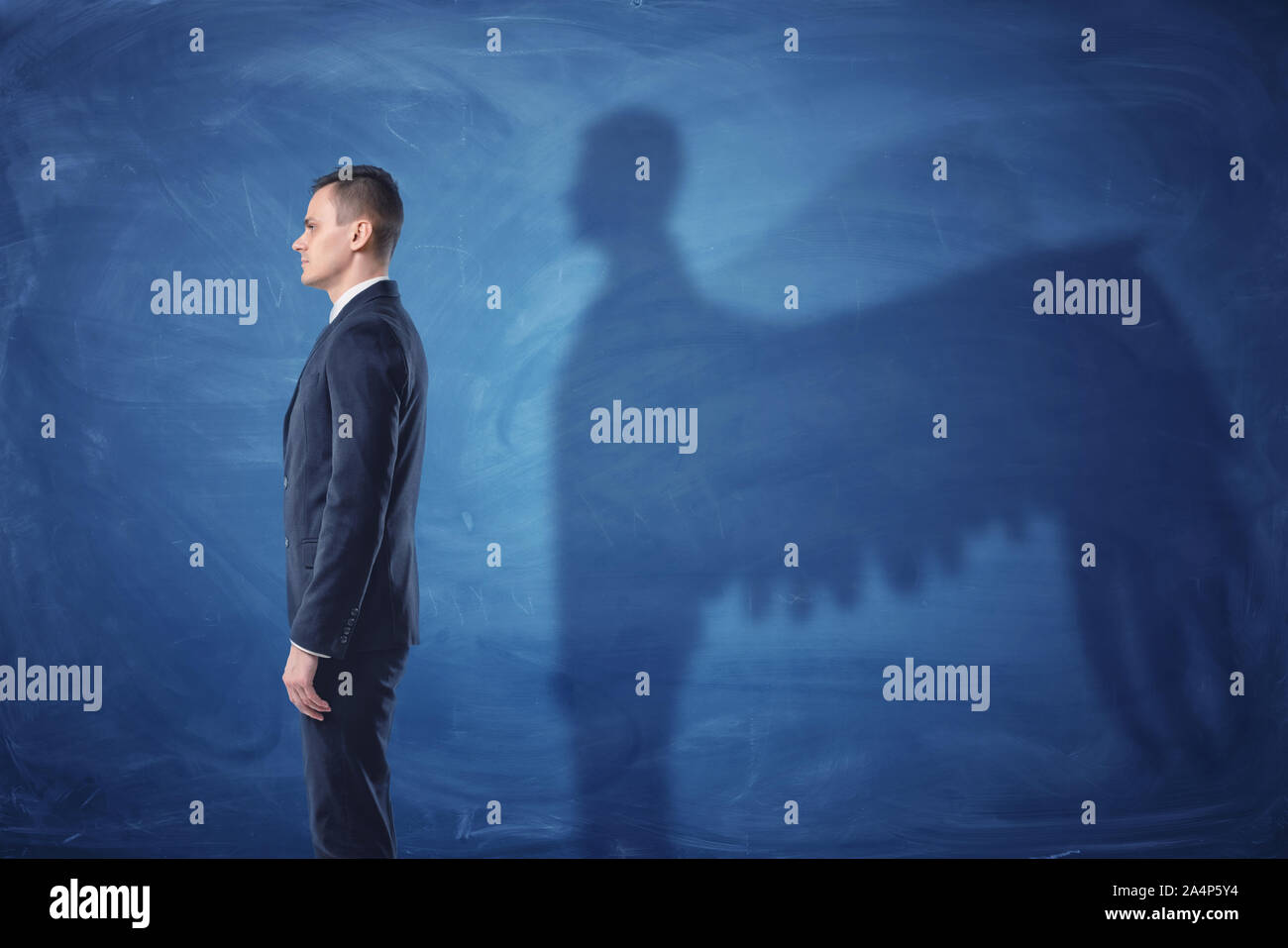 Businessman is standing in profile and casting a shadow of angel wings ... Businessman is standing in profile and casting a shadow of angel wings ...
