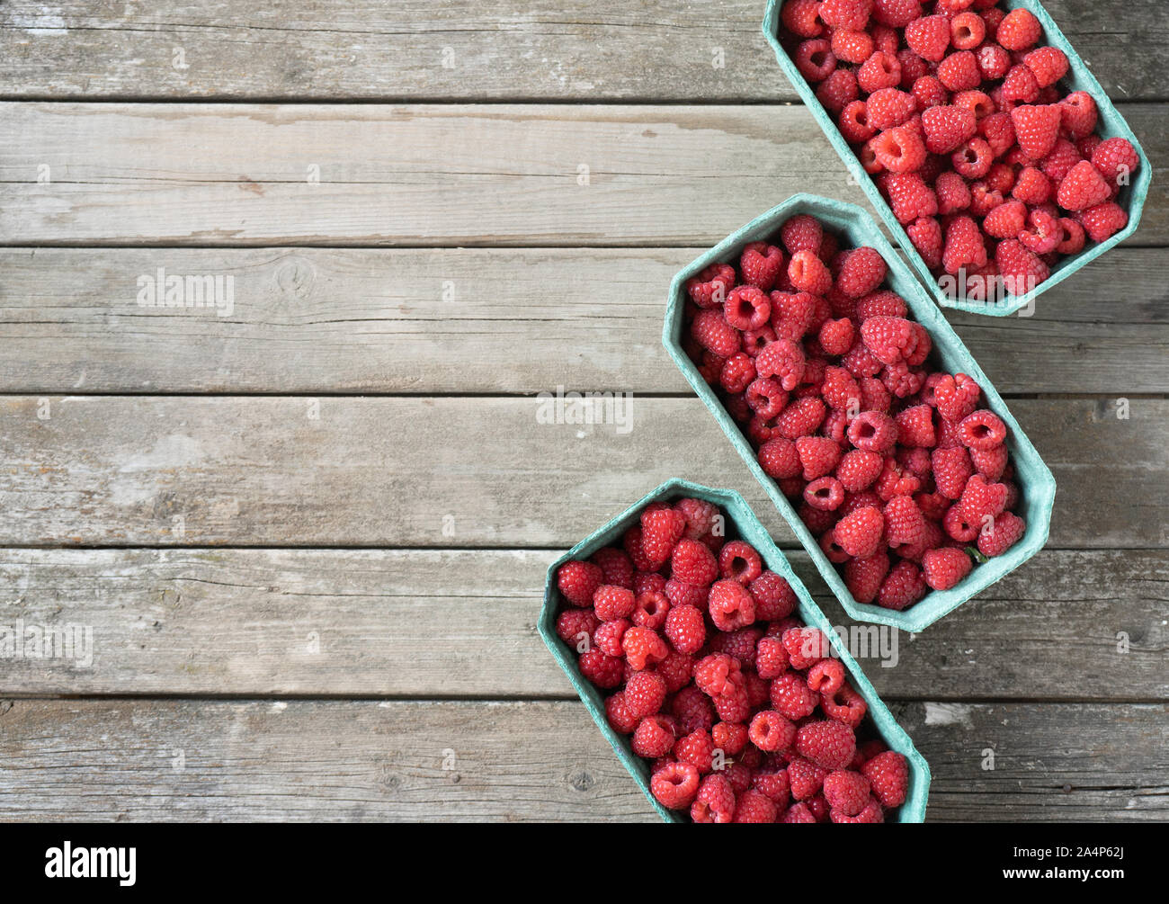 ripe raspberry in tray on wooden table Stock Photo - Alamy