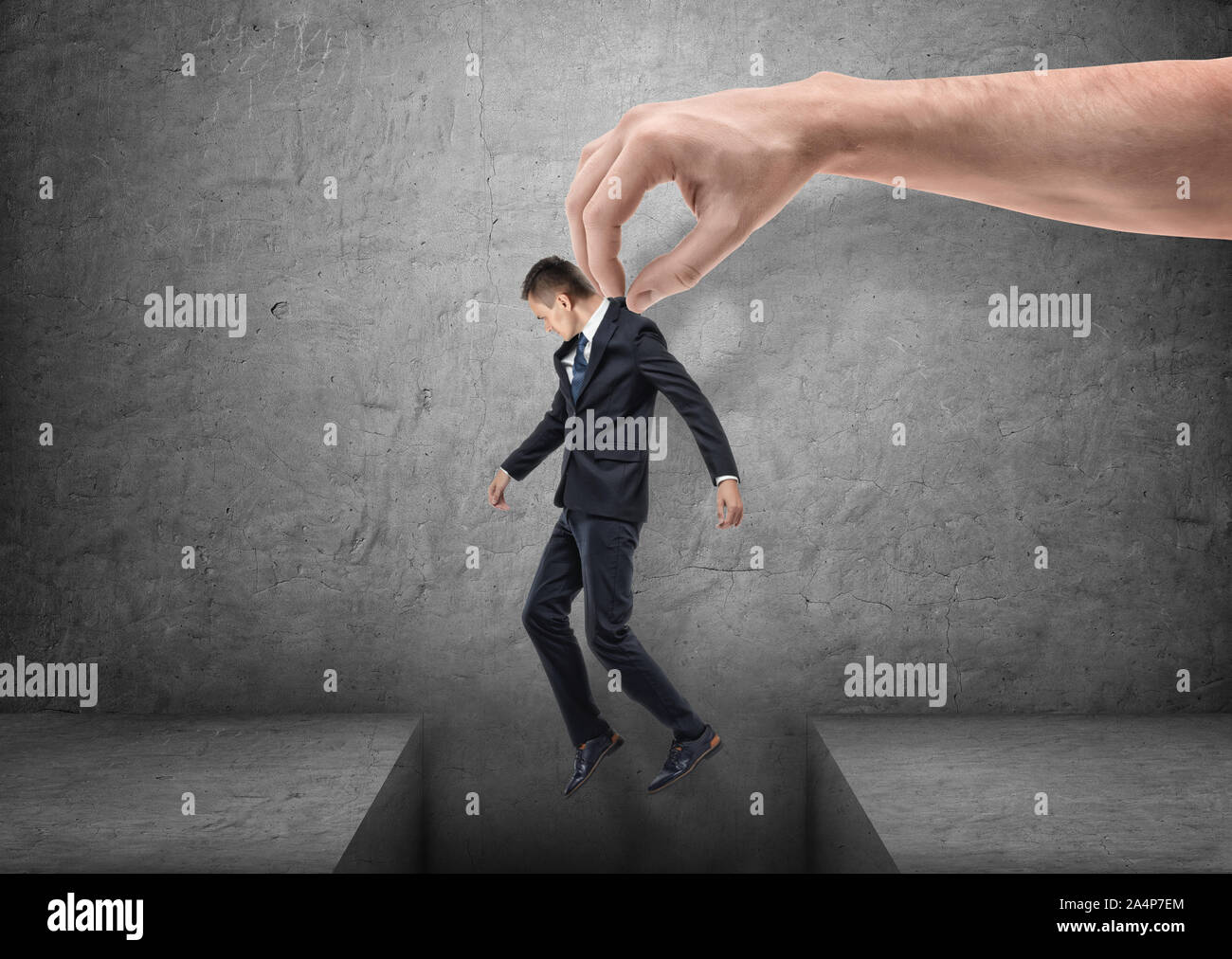 Big hand is bringing a businessman over a gap in the floor on gray ...