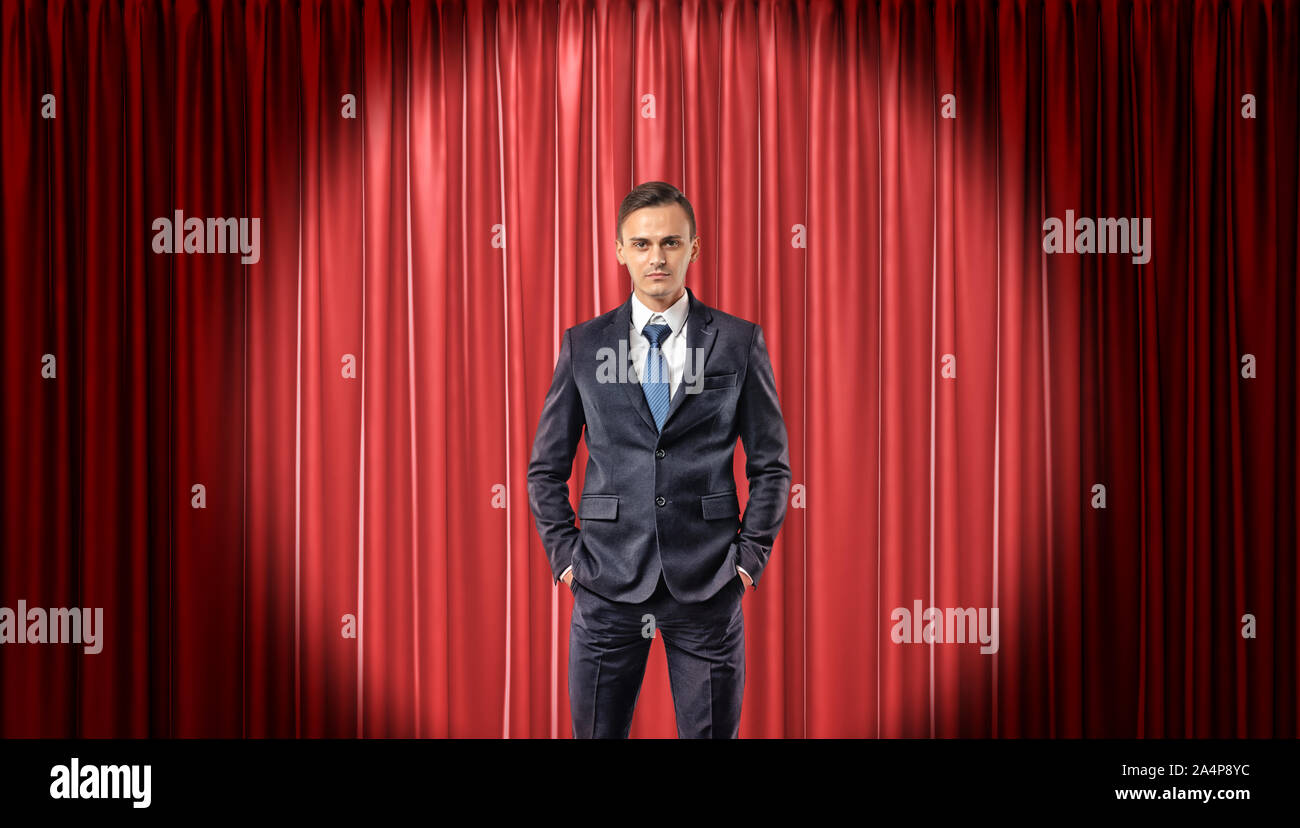 A confident businessman standing in front view in the spotlight with a ...