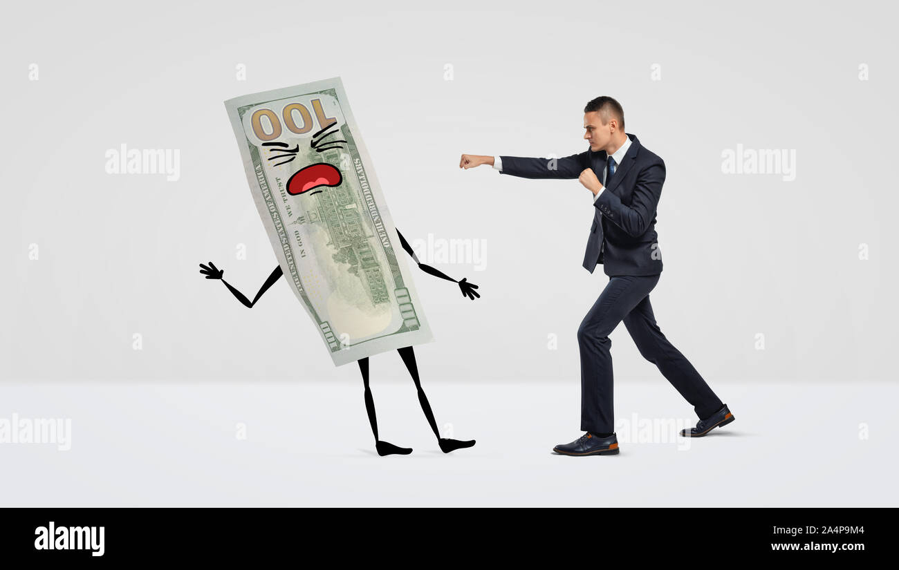 A businessman on white background boxing with a large money bill with ...