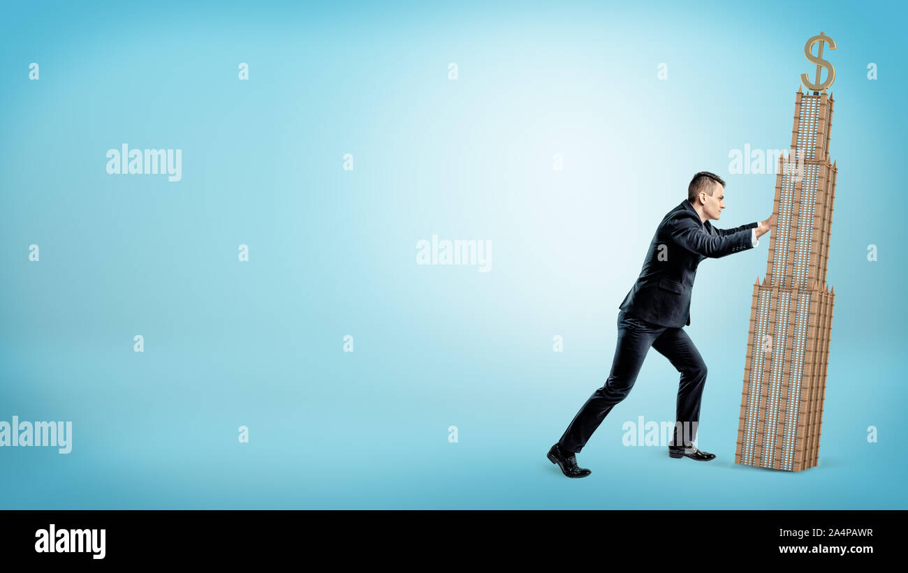 A large businessman pushing a sloping business building of the same ...