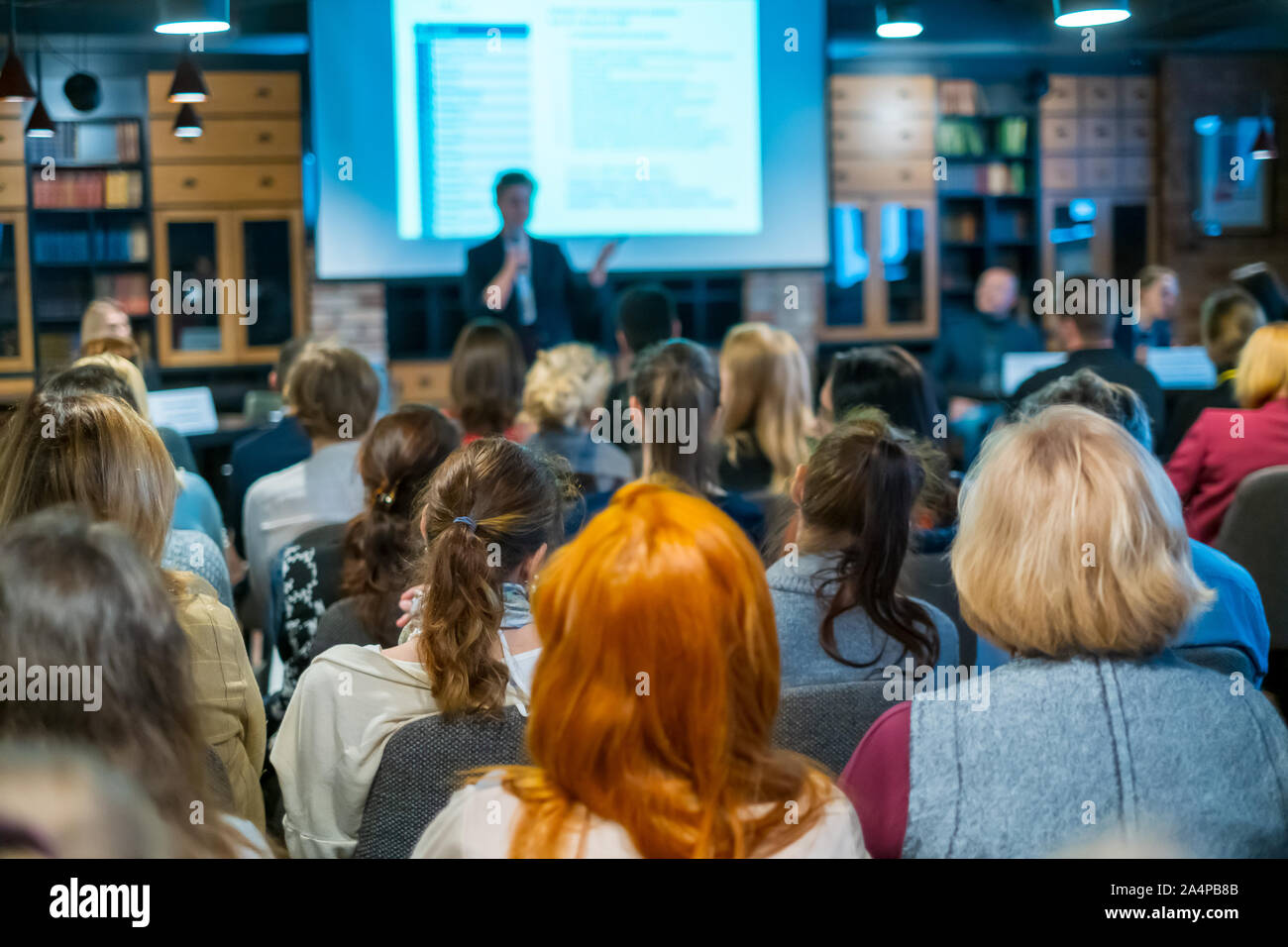 Audience listens lecturer at workshop in conference hall, rear view Stock Photo - Alamy