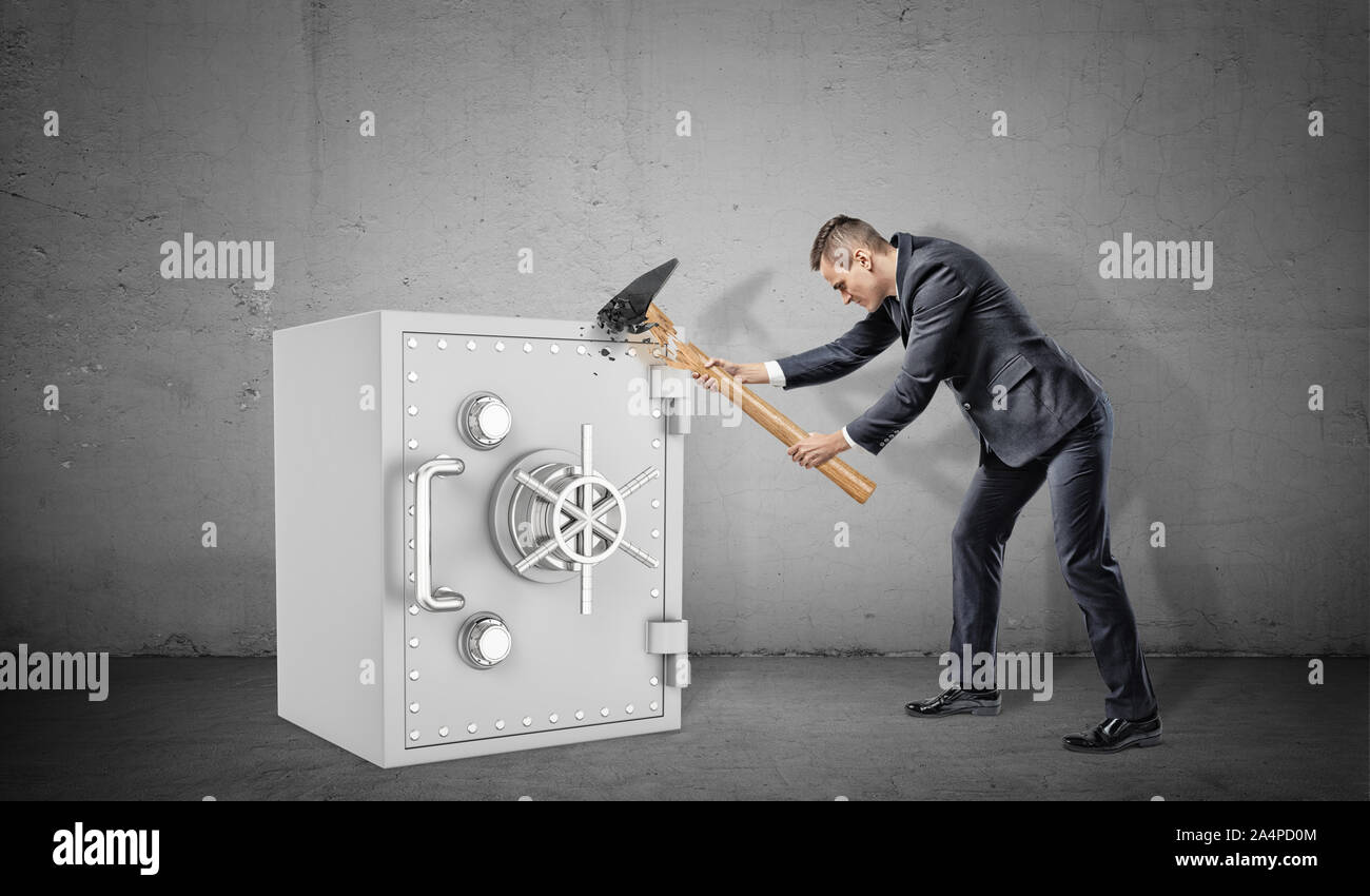 A businessman on concrete background fails to destroy a large solid ...