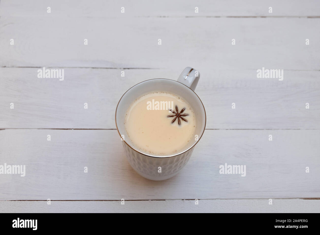 Indian milk tea masala in white ceramic mug on white wooden background ...