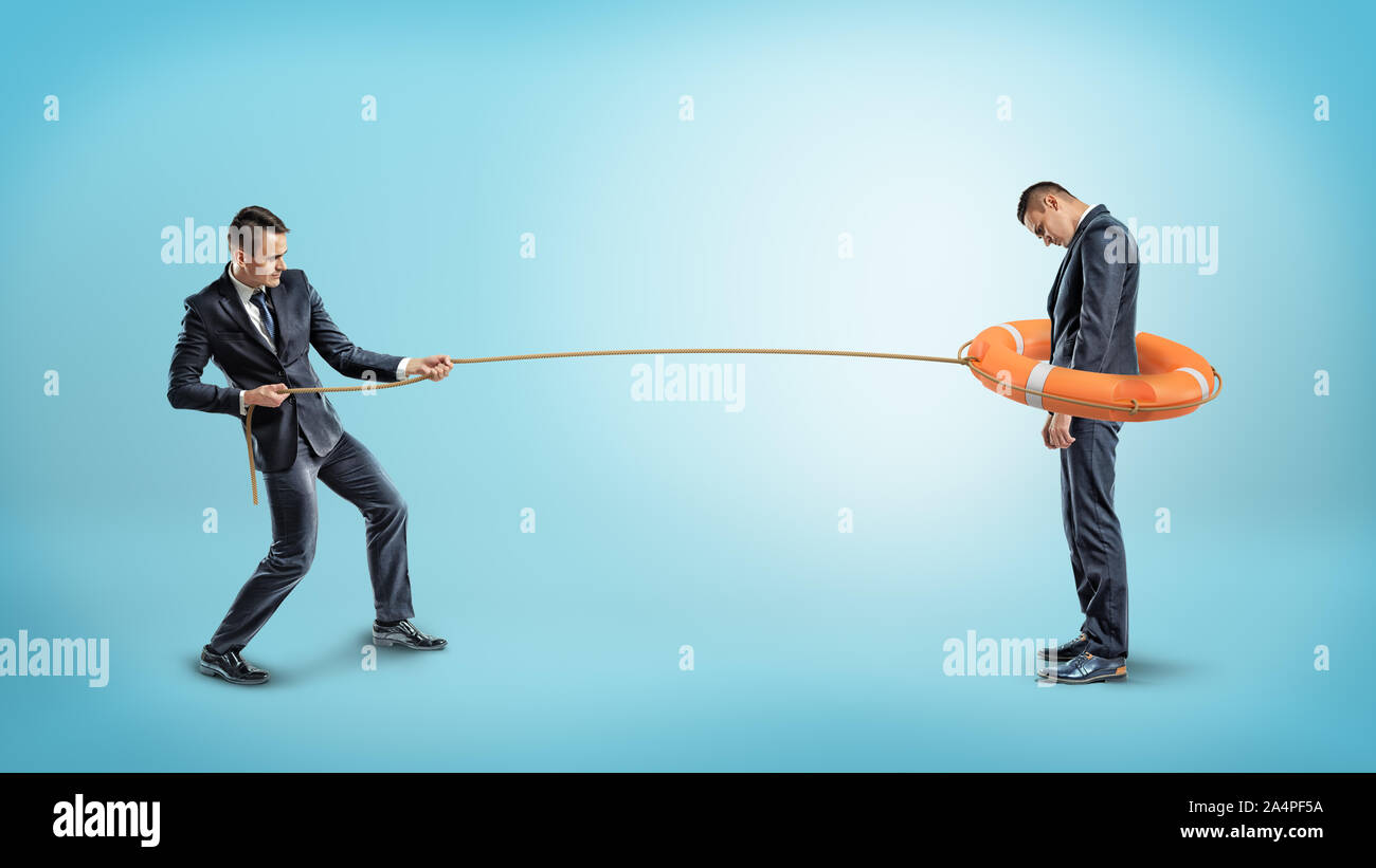 A businessman catches another man with an orange life buoy used as a ...