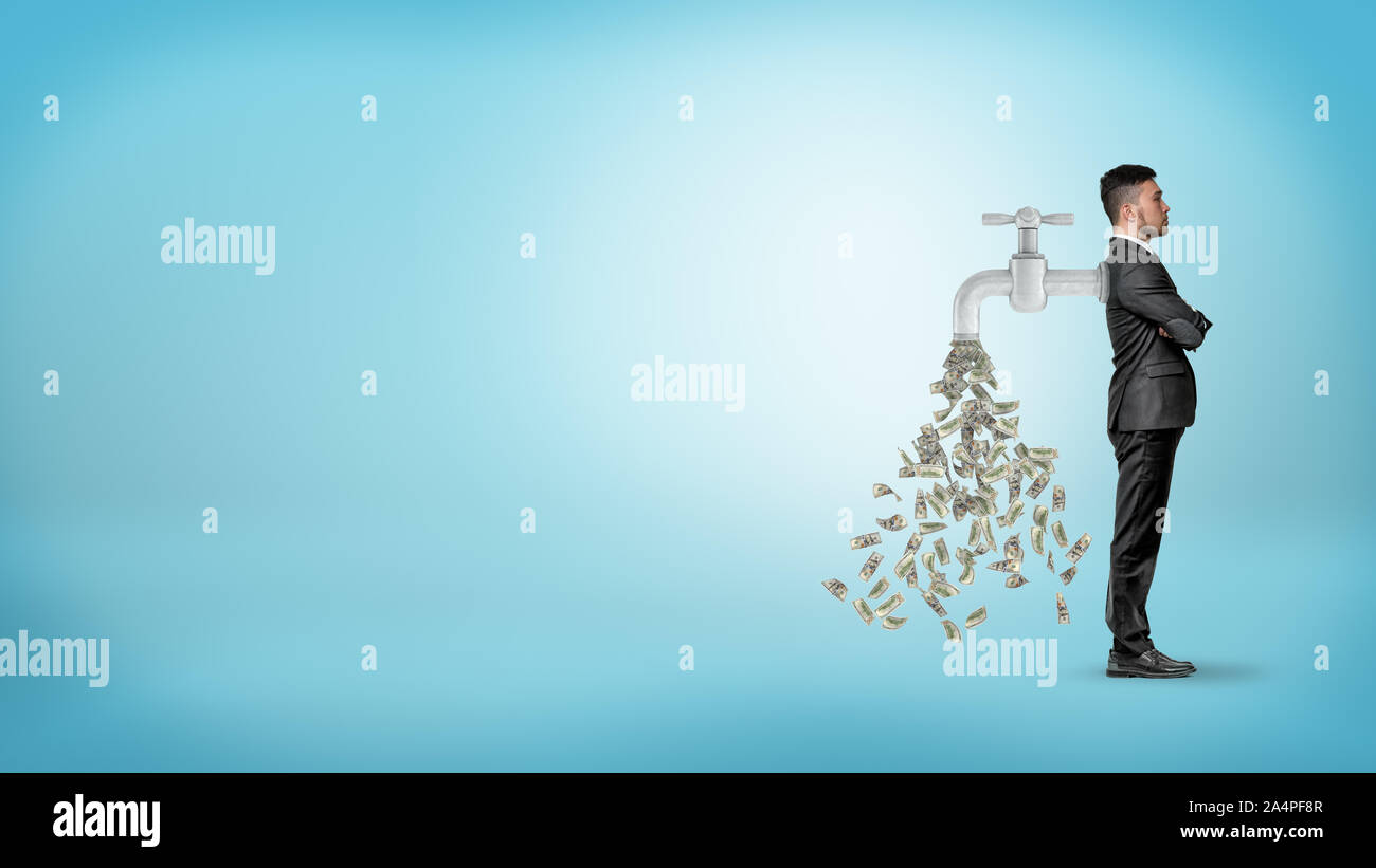 A businessman stands in a side view with a large faucet attached to his ...