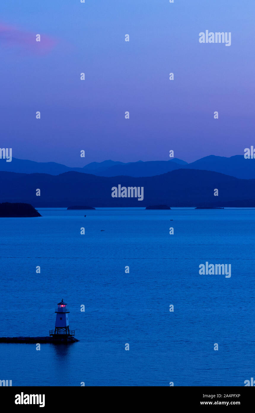 Lighthouse on Lake Champlain at dusk with Adirondack mountains in ...