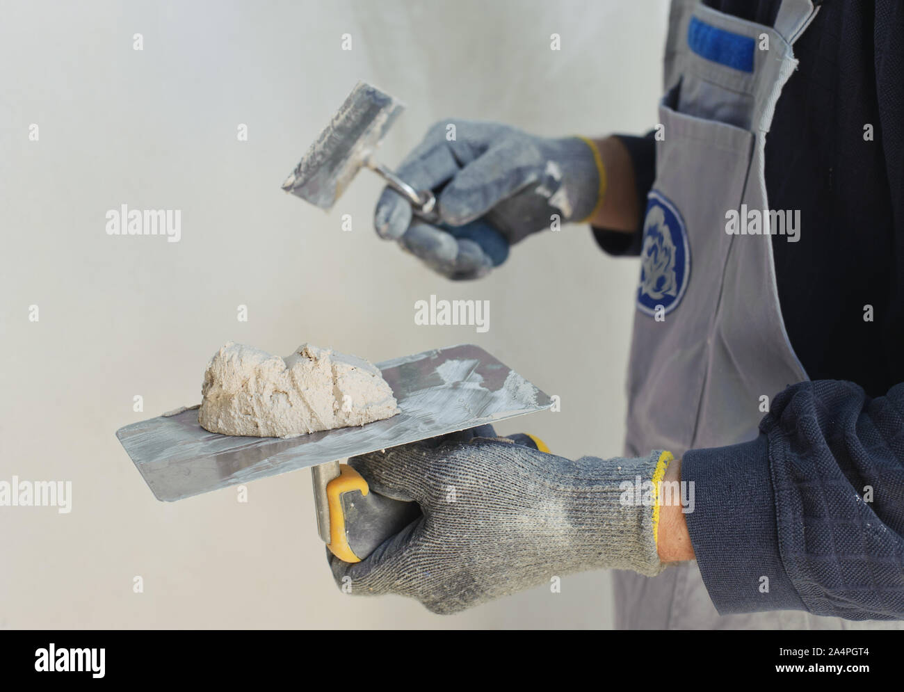 Gypsum puttying manually. Man's hands with a trowel applied and smooth ...