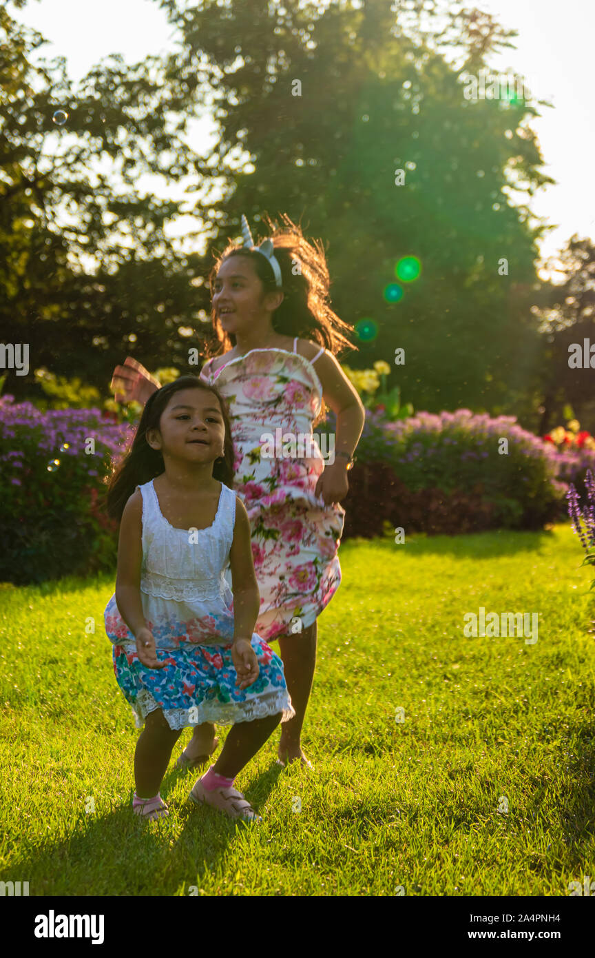 Cute Mexican American children are playing and enjoying bubbles in a ...