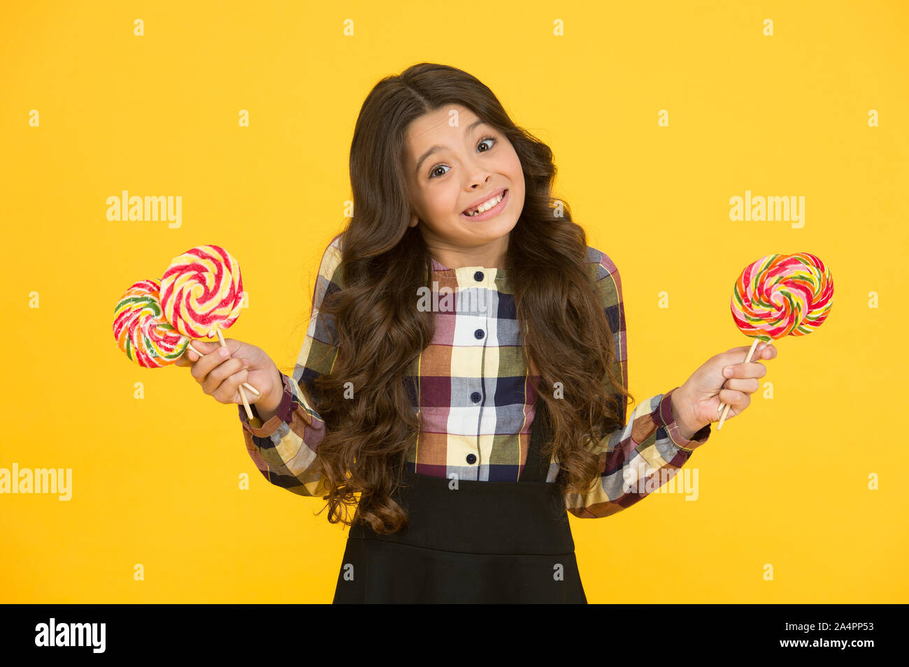 Taste the rainbow. Happy little girl hold swirl candy. Small child ...