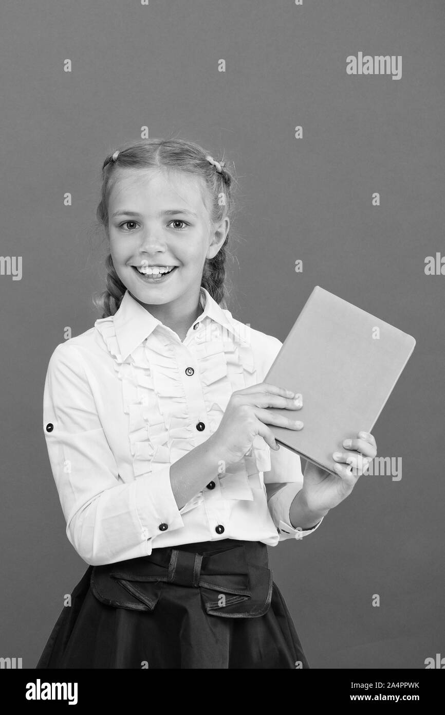 All of her knowledge is from book. Adorable small girl holding book on ...