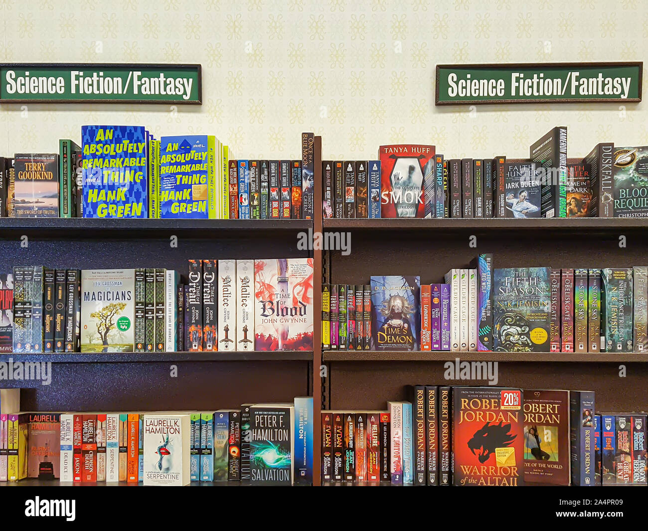 Rows of different colorful books lying on the shelves in the modern ...