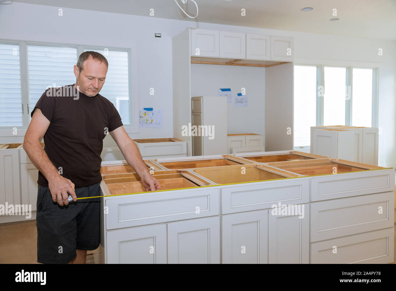Man using tape measure for measuring size in modern kitchen material ...