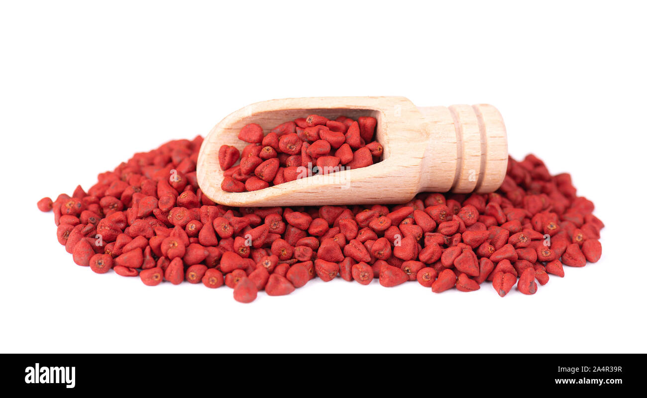 Annatto seeds, in the wooden spoon, isolated on white background ...