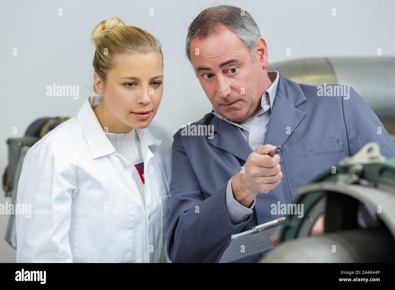 middle-aged male engineer training young female apprentice Stock Photo ...