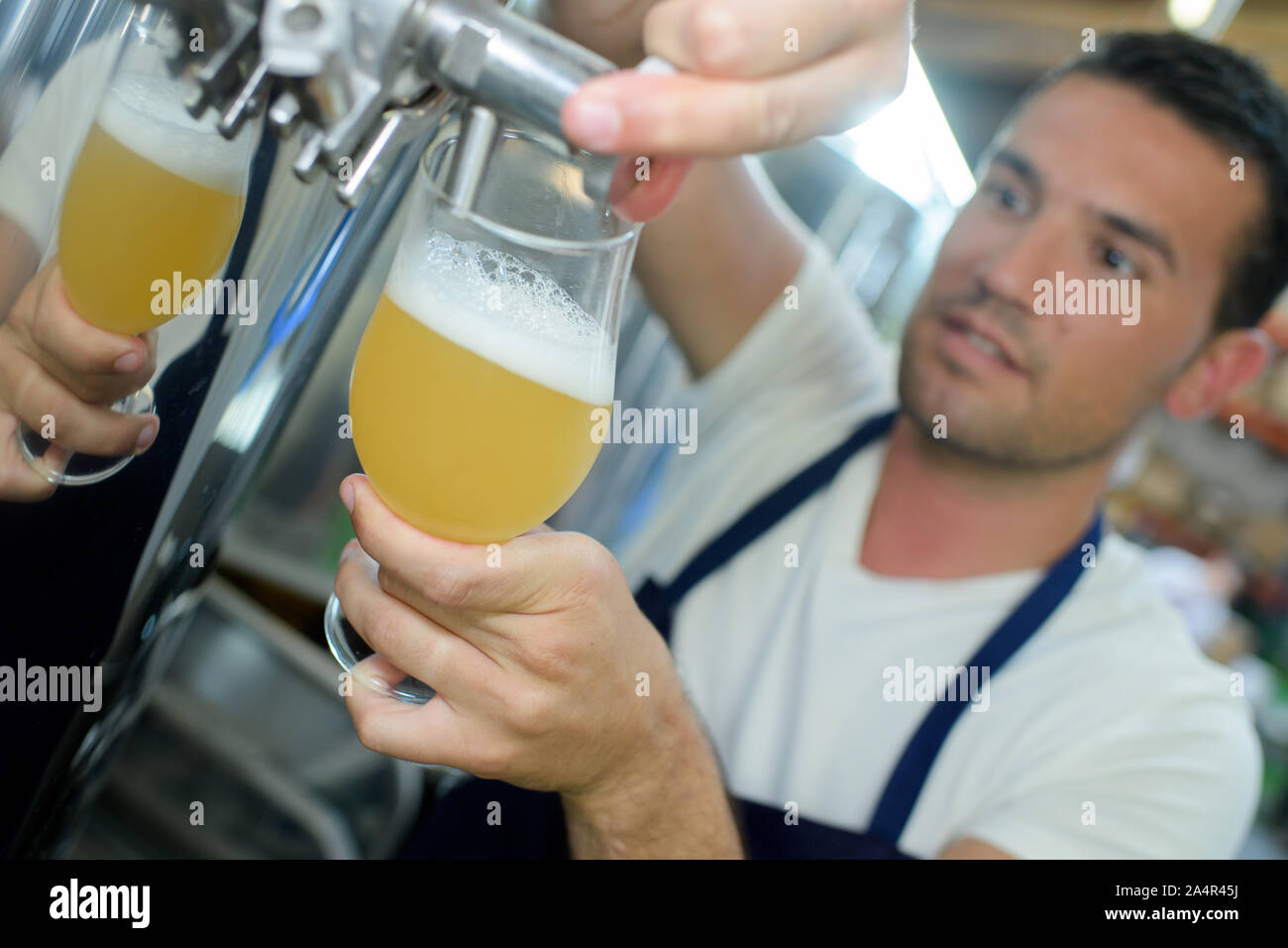 bartender pouring beer in a glass at bar counter Stock Photo - Alamy
