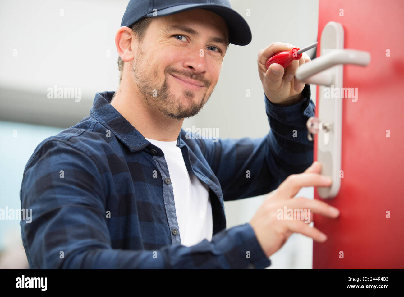 a happy handyman installing kitchen cupboard Stock Photo - Alamy