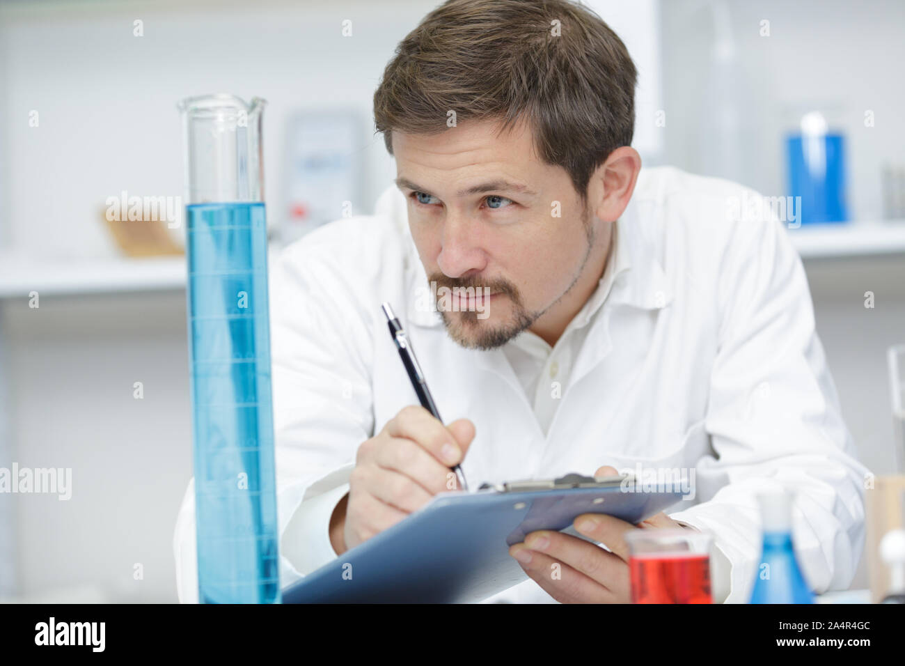 scientist writing test results in lab Stock Photo - Alamy