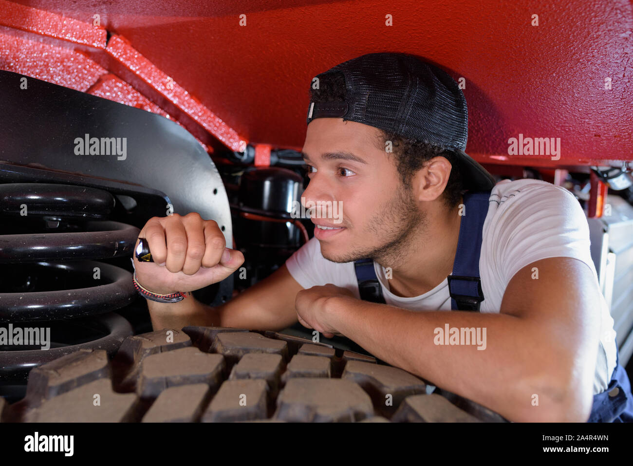 male mechanic using a torch to inspect vehicle Stock Photo - Alamy