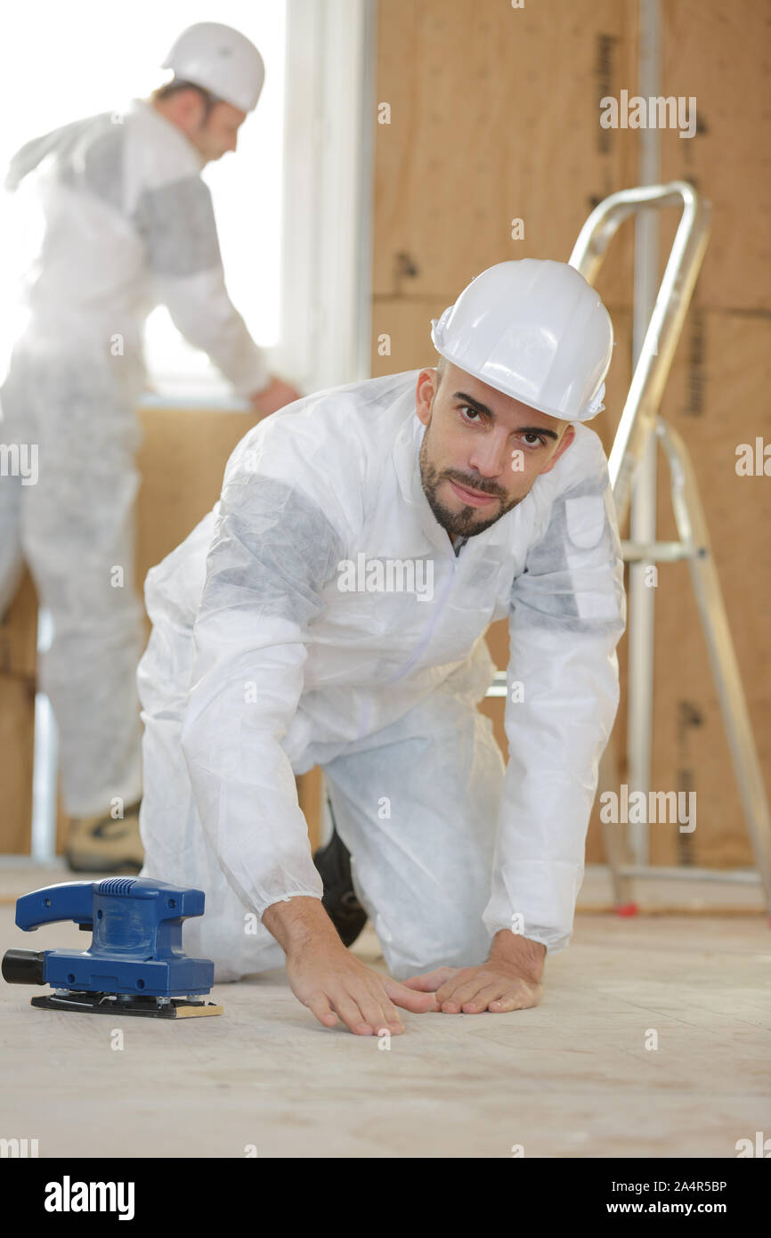 portrait of man feeling surface of floor about using sander Stock Photo ...