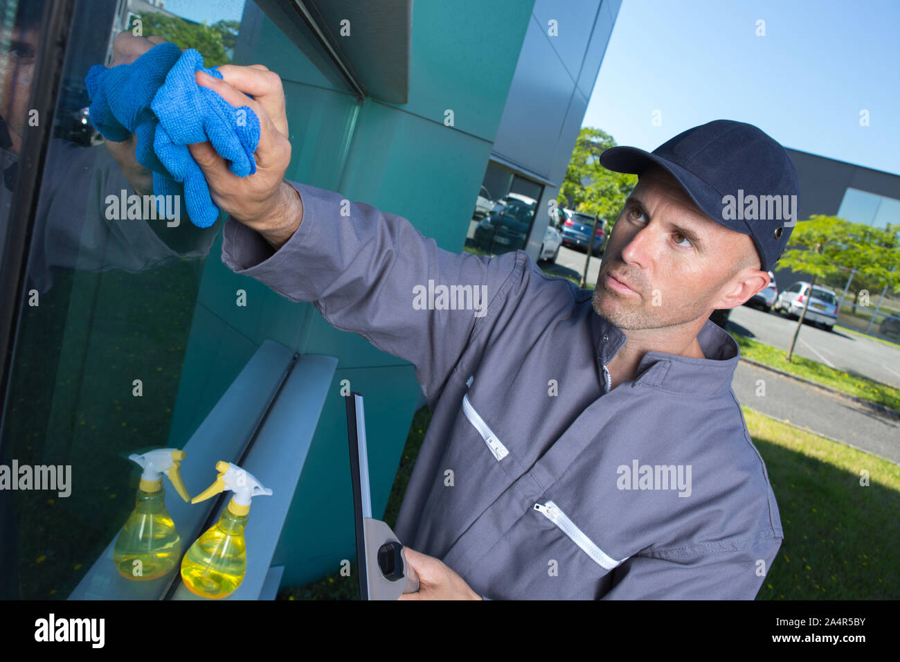 young man cleaning window in office Stock Photo - Alamy