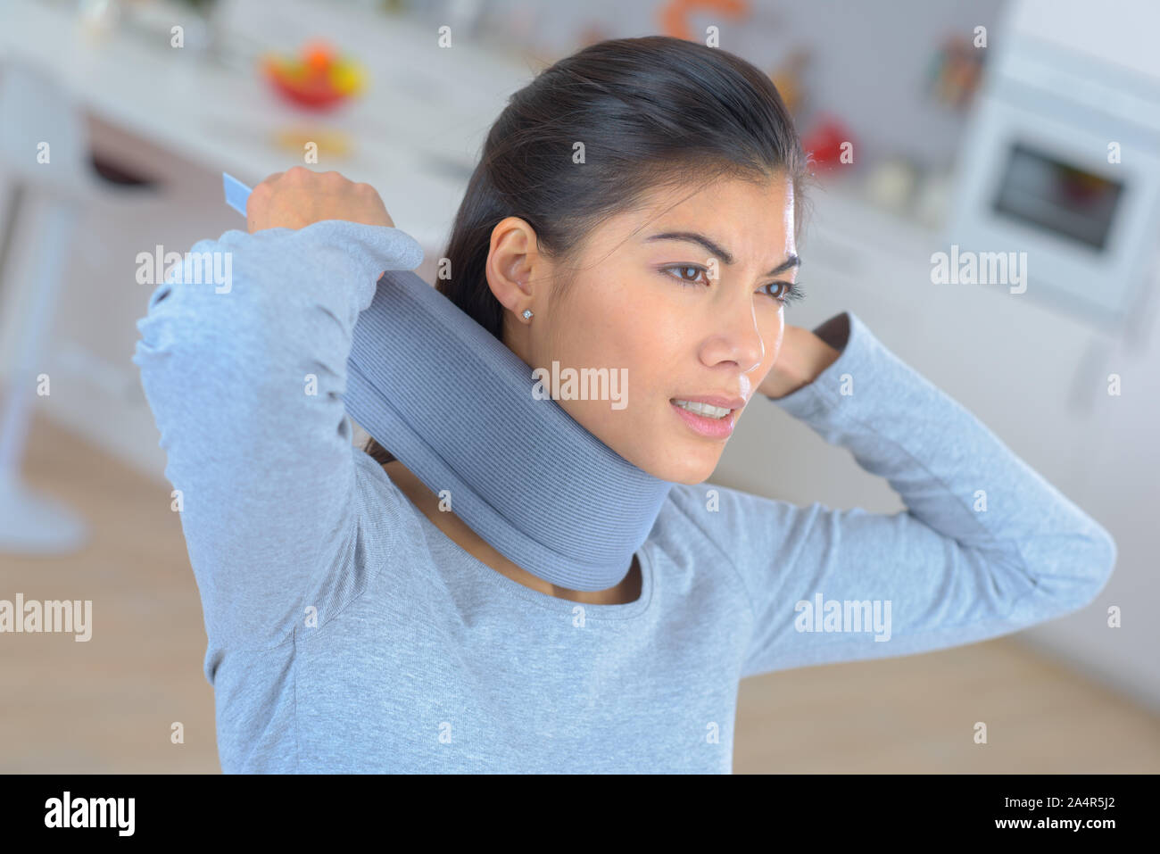woman securing neck brace on herself Stock Photo - Alamy