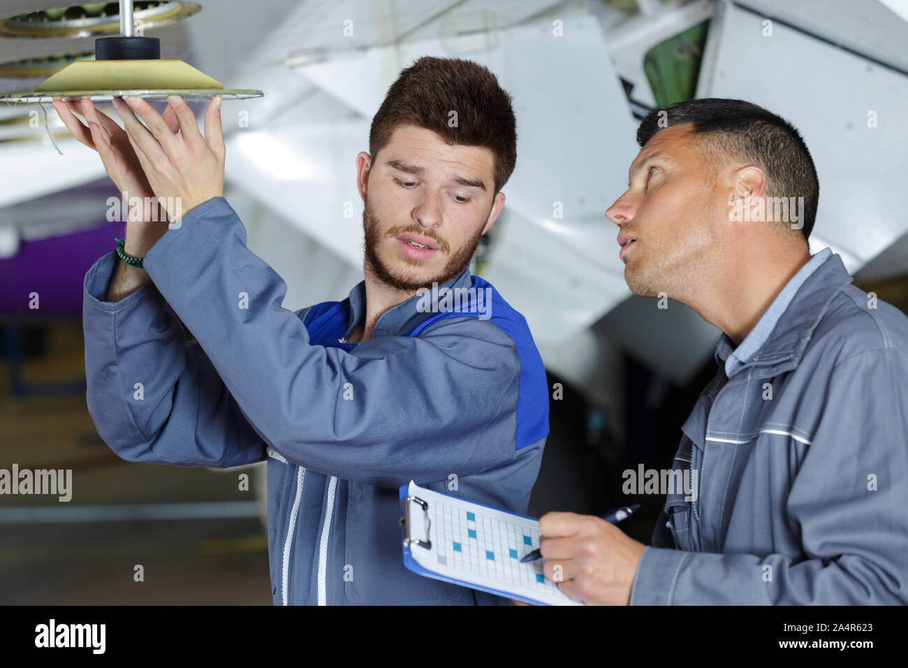 airplane service crew repairing plane in hangar Stock Photo - Alamy