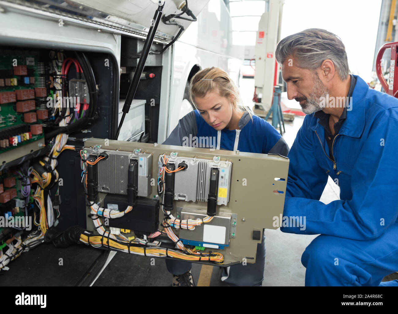 two bus mechanics on wiring Stock Photo - Alamy