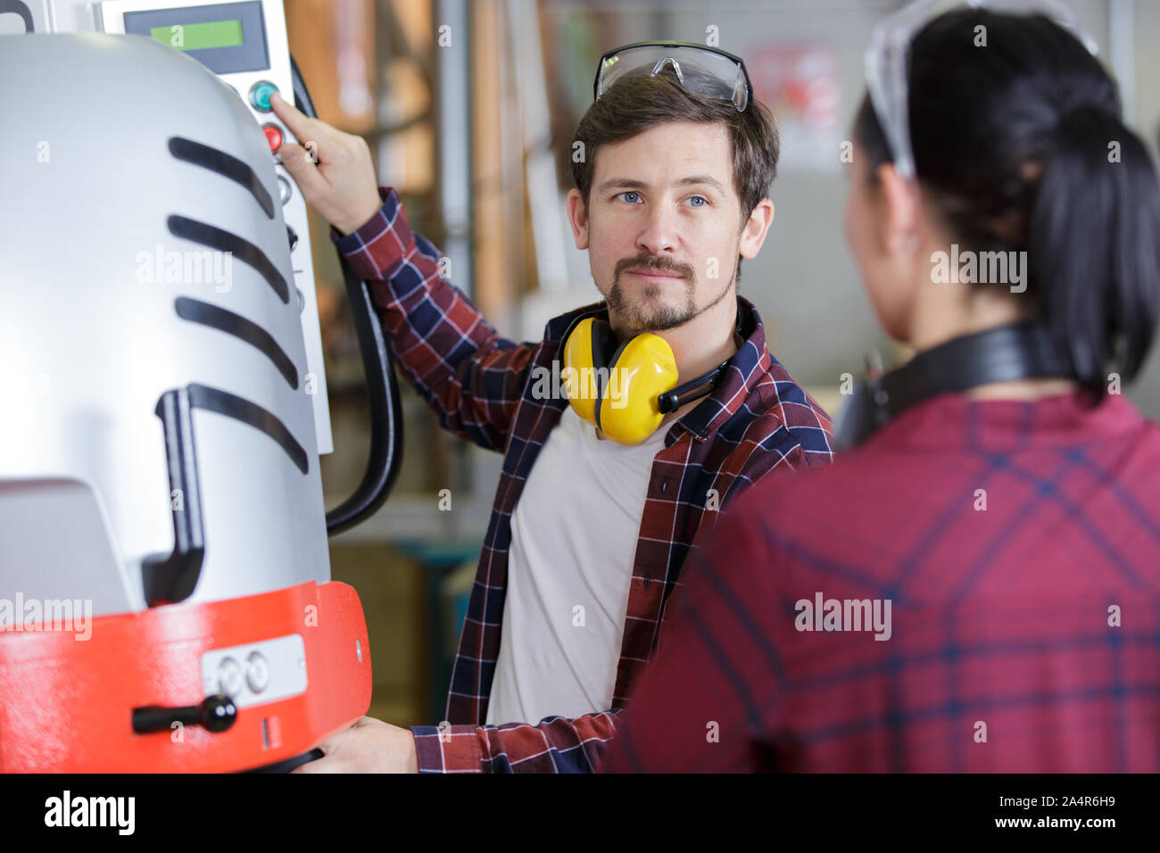 craftsman and female worker checking machine Stock Photo - Alamy