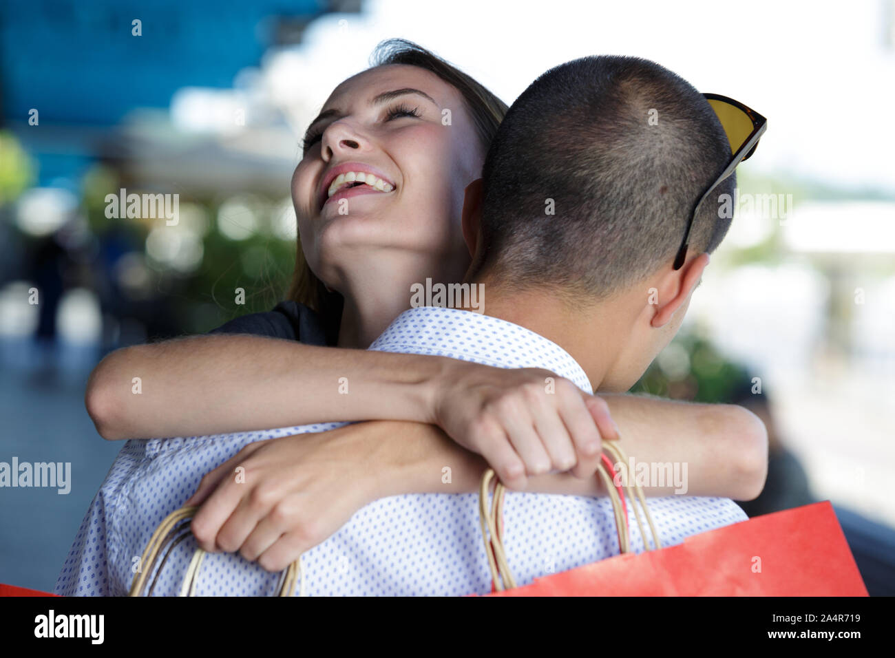 happy girlfriend hugging partner for shopping treat Stock Photo - Alamy