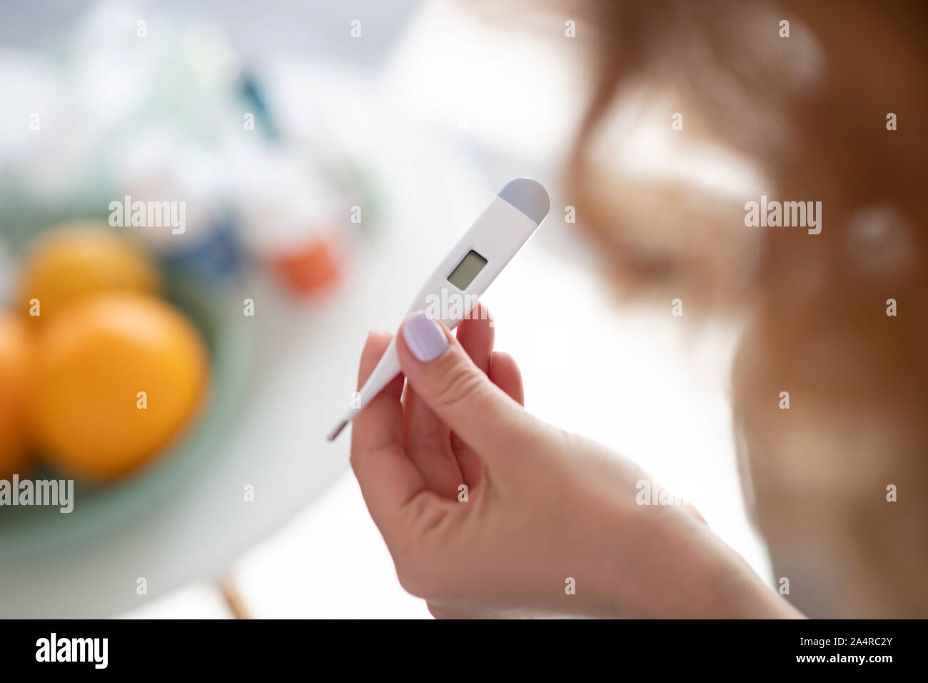 Close up of woman holding thermometer while checking temperature Stock ...