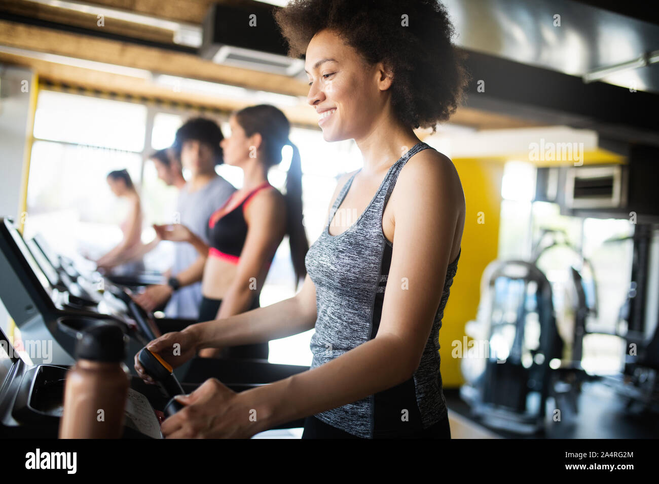 Beautiful fit people exercising together in gym Stock Photo - Alamy