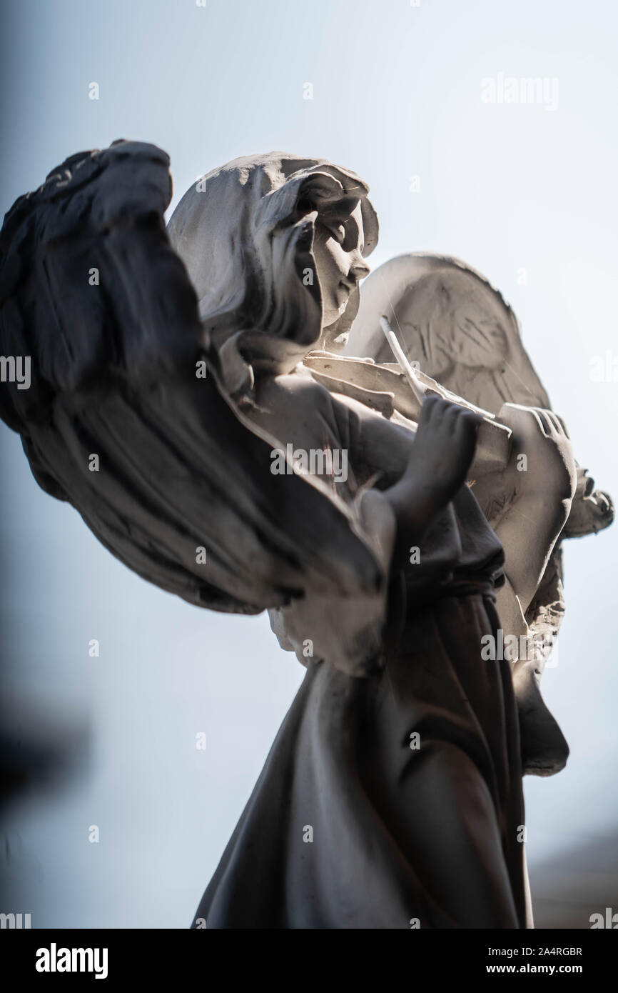 Statue of an angel playing violin in the garden Stock Photo - Alamy
